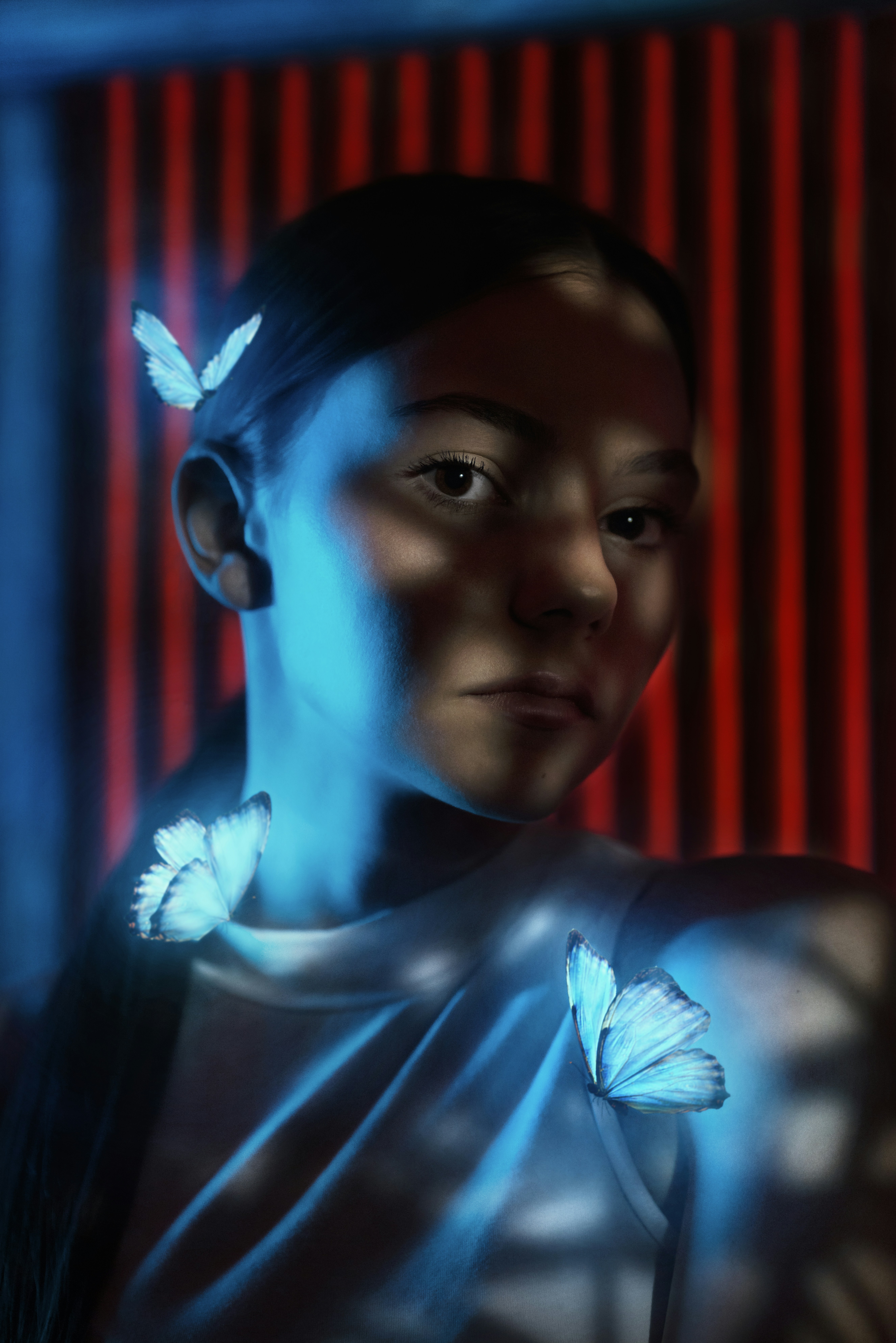 Neon Butterflies: A Portrait in Blue Light and Red Stripes