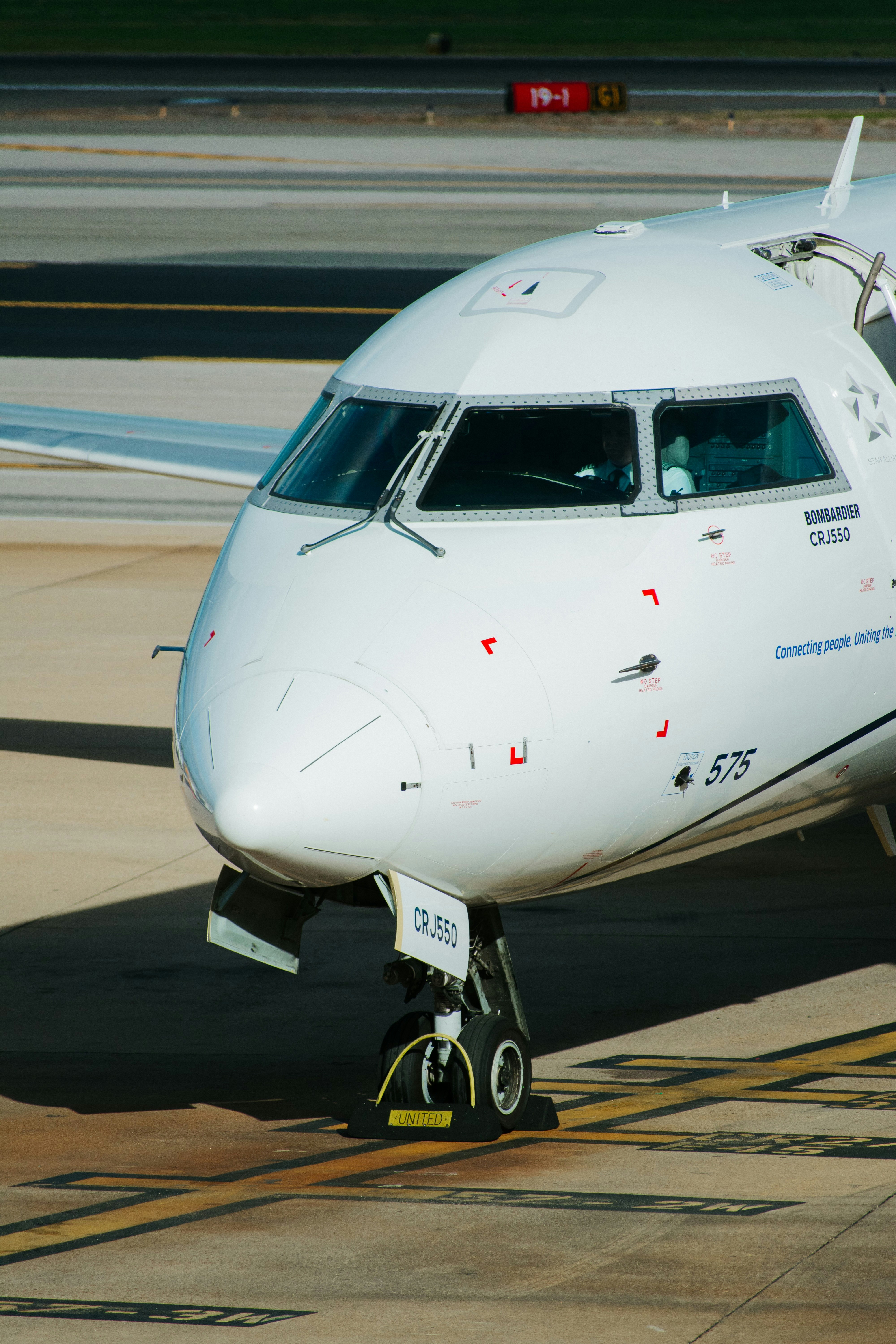 Commercial airplane positioned on airport runway under clear skies.