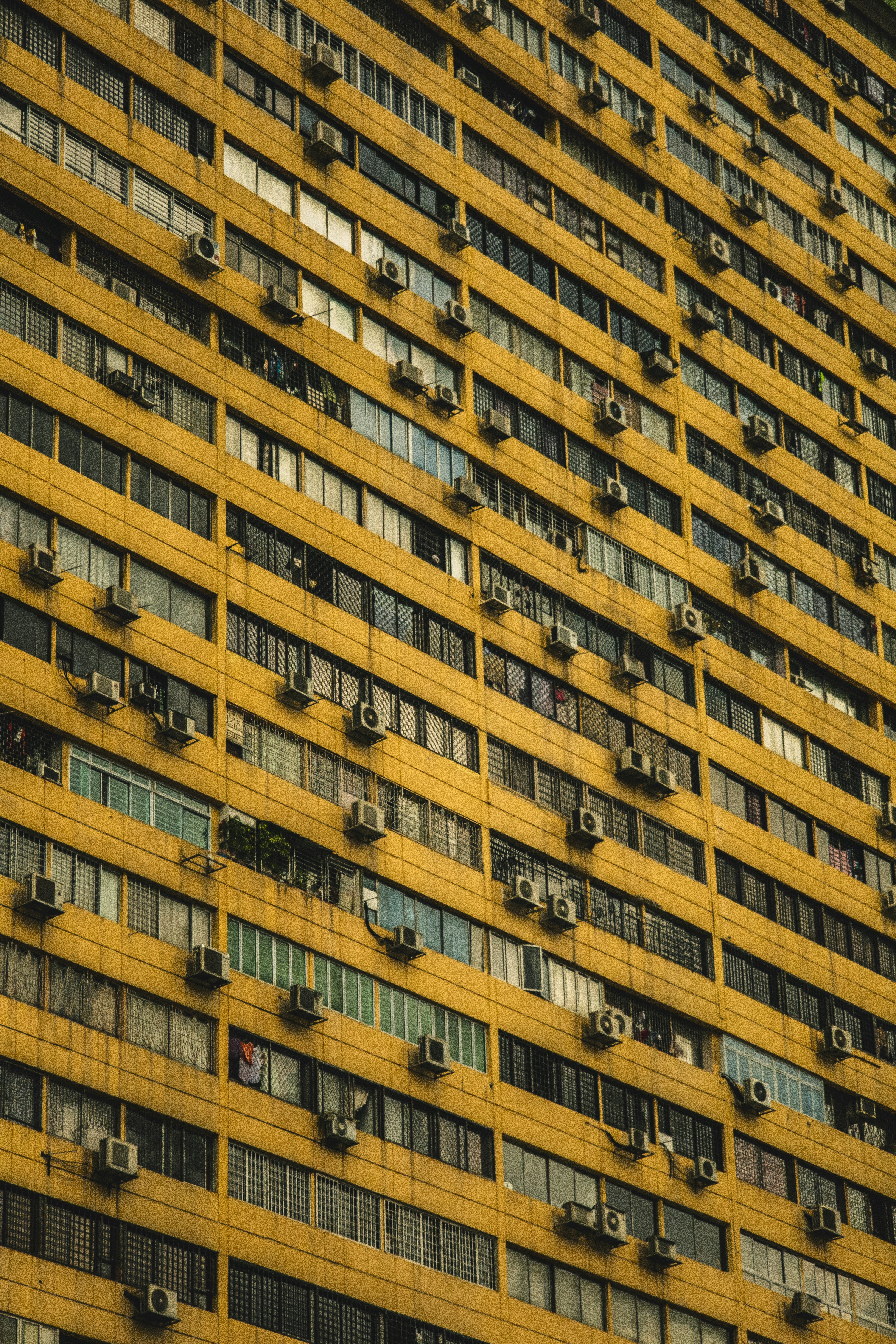 A very tall yellow building with lots of windows photo – Free City ...
