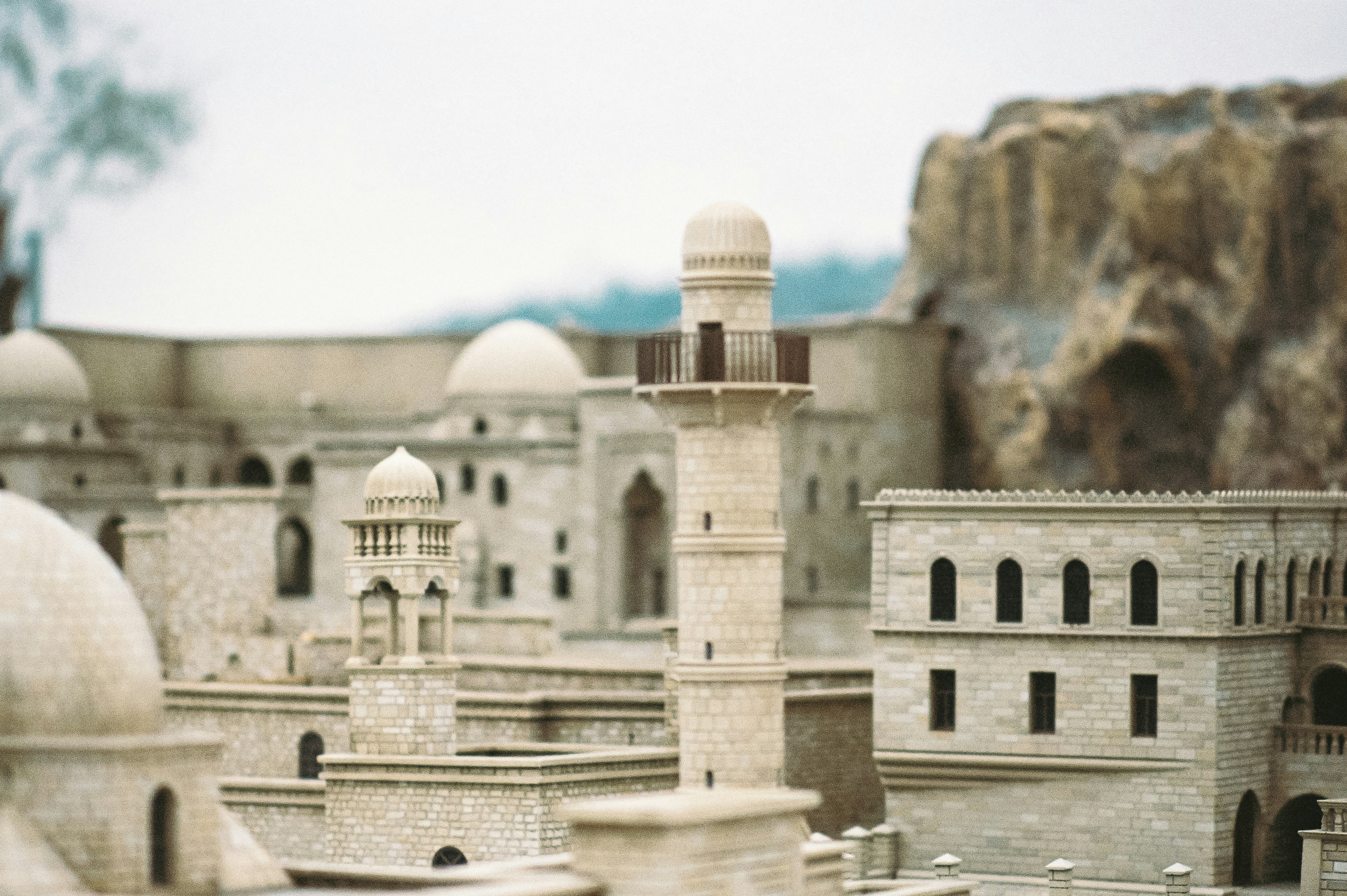 Detailed miniature model of Middle Eastern architecture with domes and towers, set against a rocky backdrop.