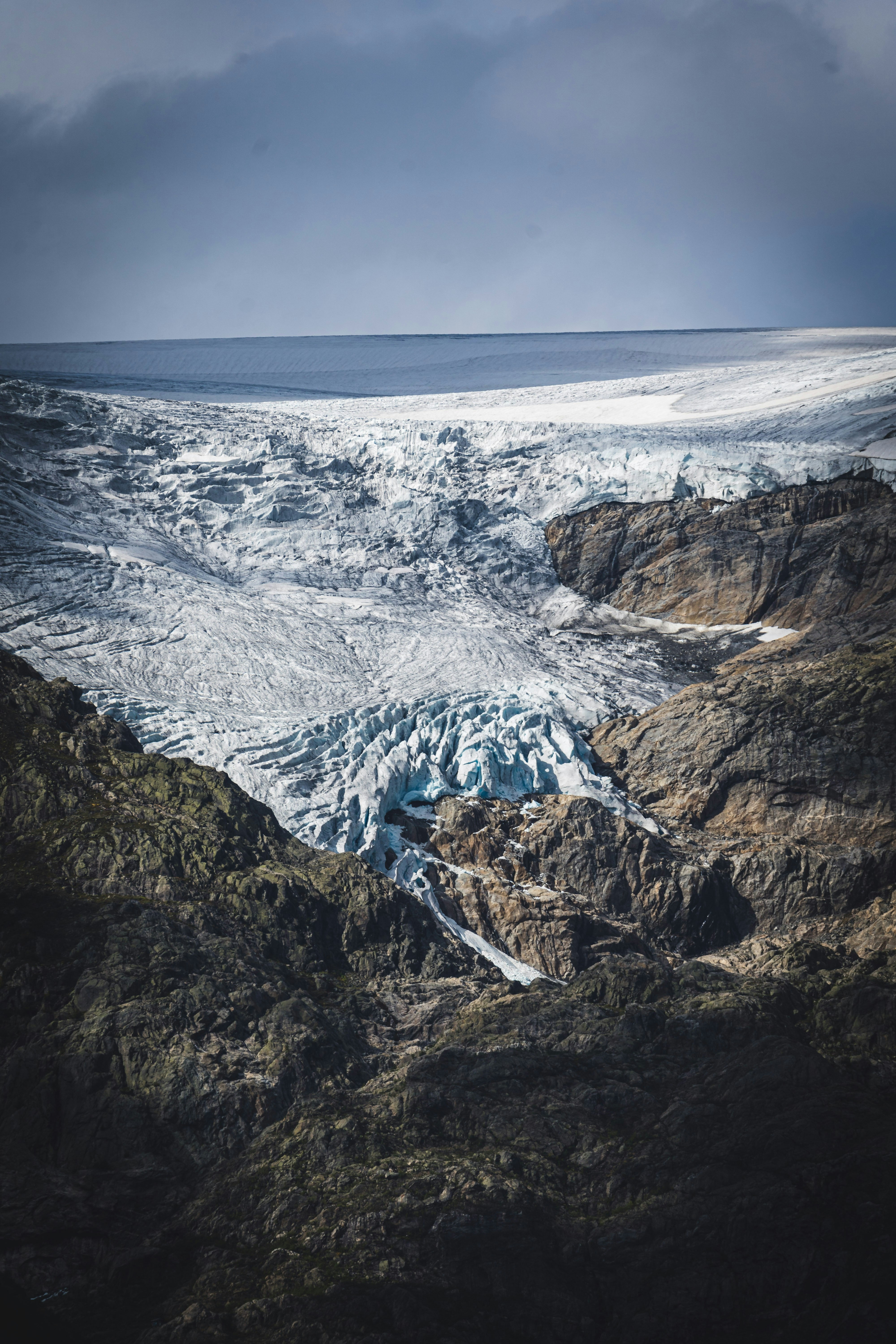 Blue Crevasse at the Glacier's Edge: Ice, Rock, and Light