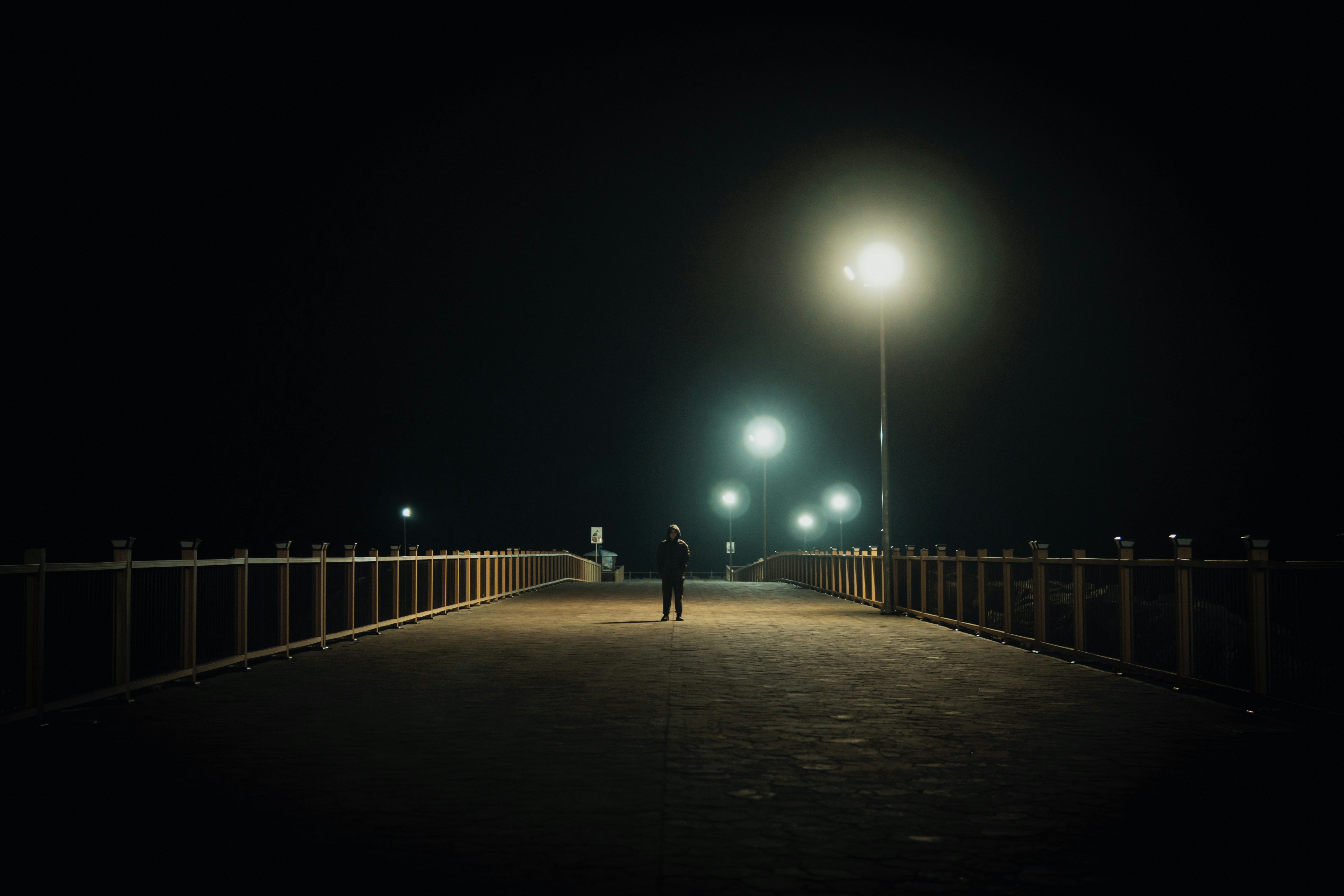 A person walking across a bridge at night photo – Free Night Image on ...