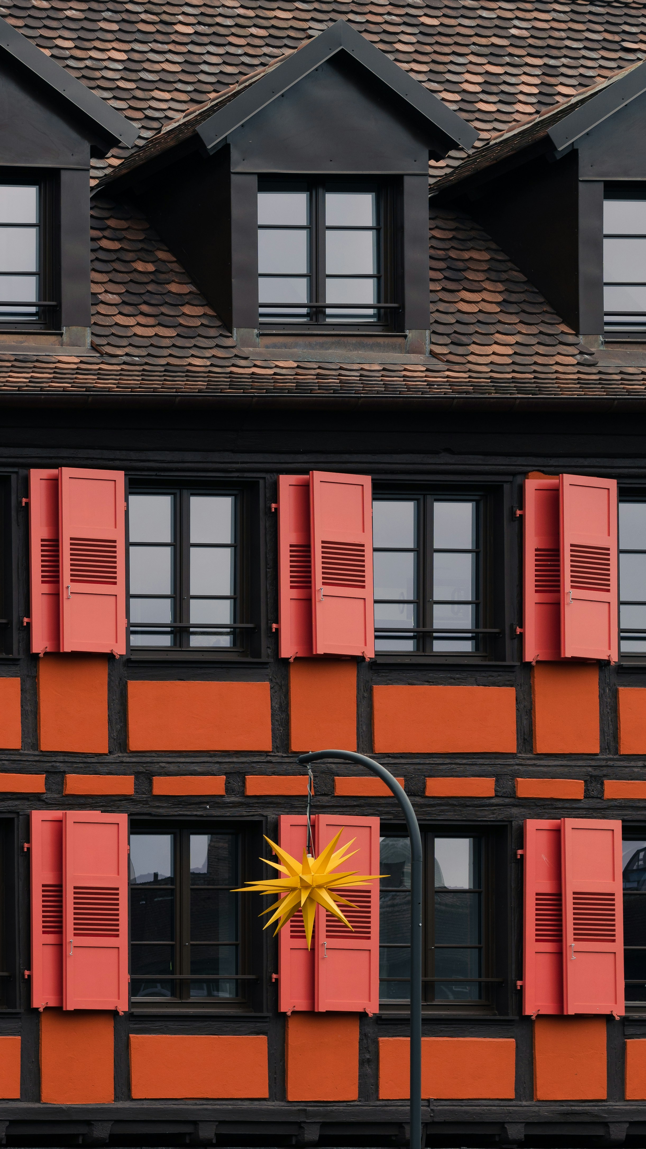 Orange Fachwerk Facade with Red Shutters and Hanging Star