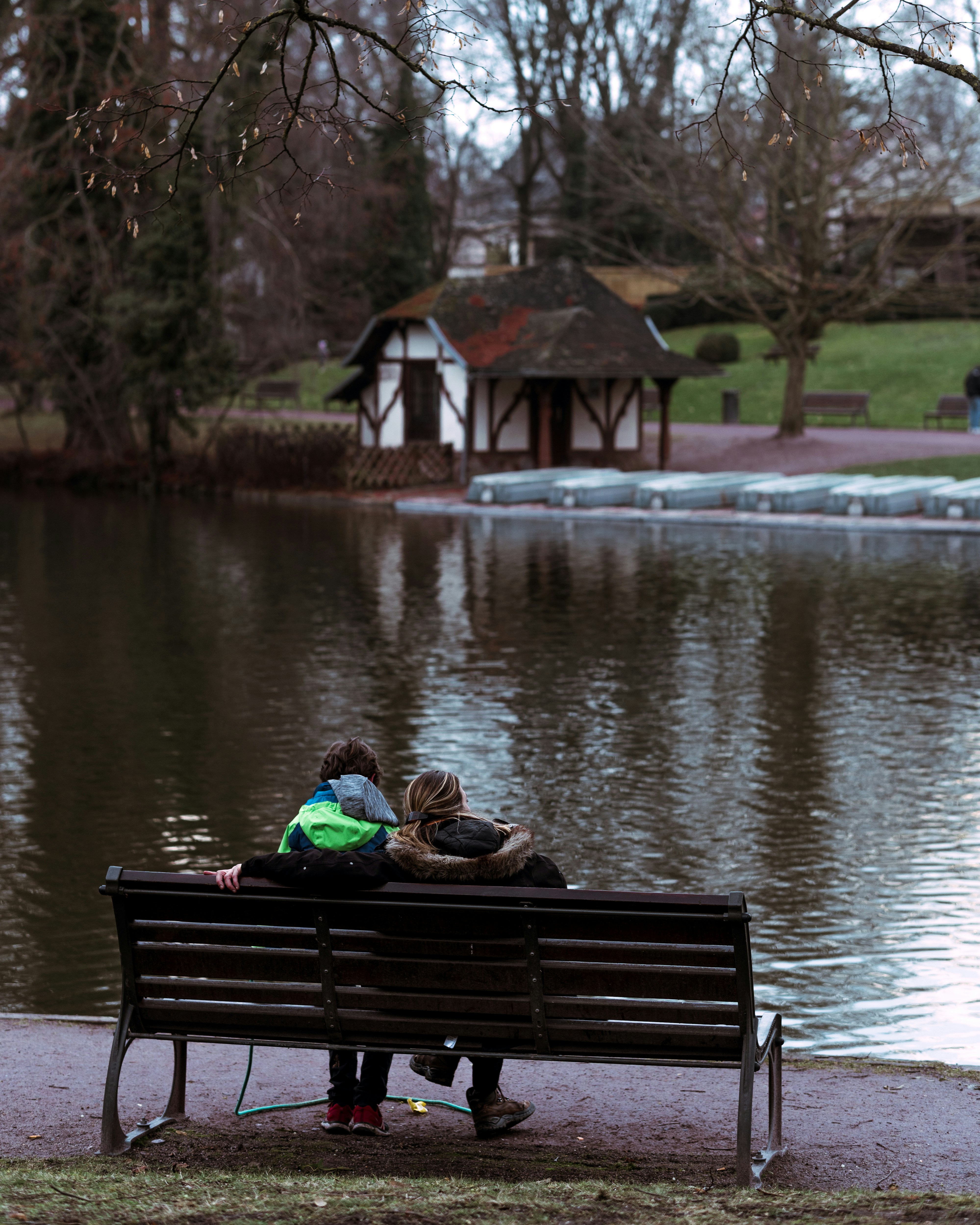 Deux personnes assises sur un banc près d’un plan d’eau photo – Photo ...