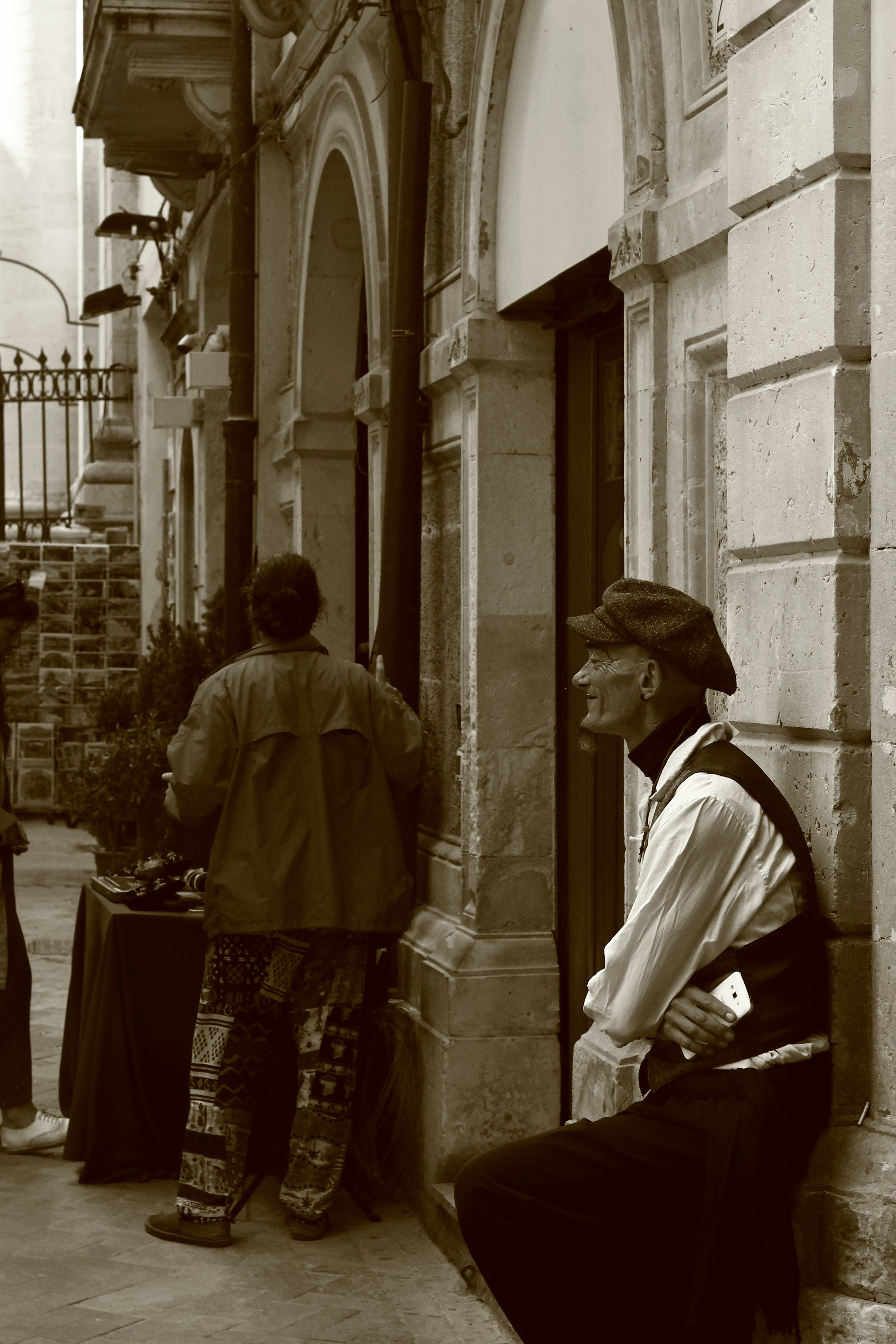 A man enjoying his time on a street corner in Ortigia Island, Sicily.