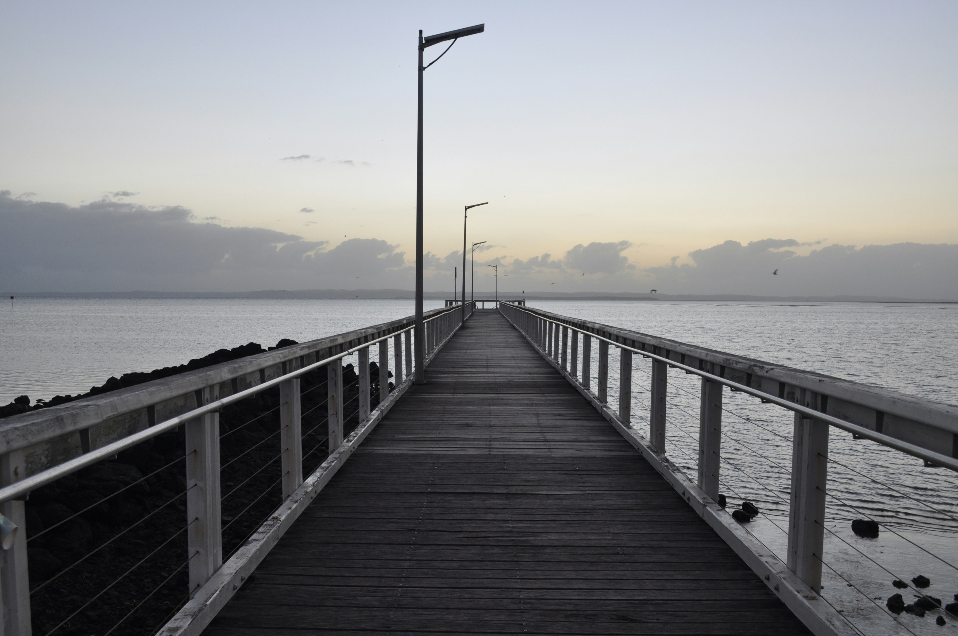 A wooden pier with a light pole and a light pole photo – Free Grey ...