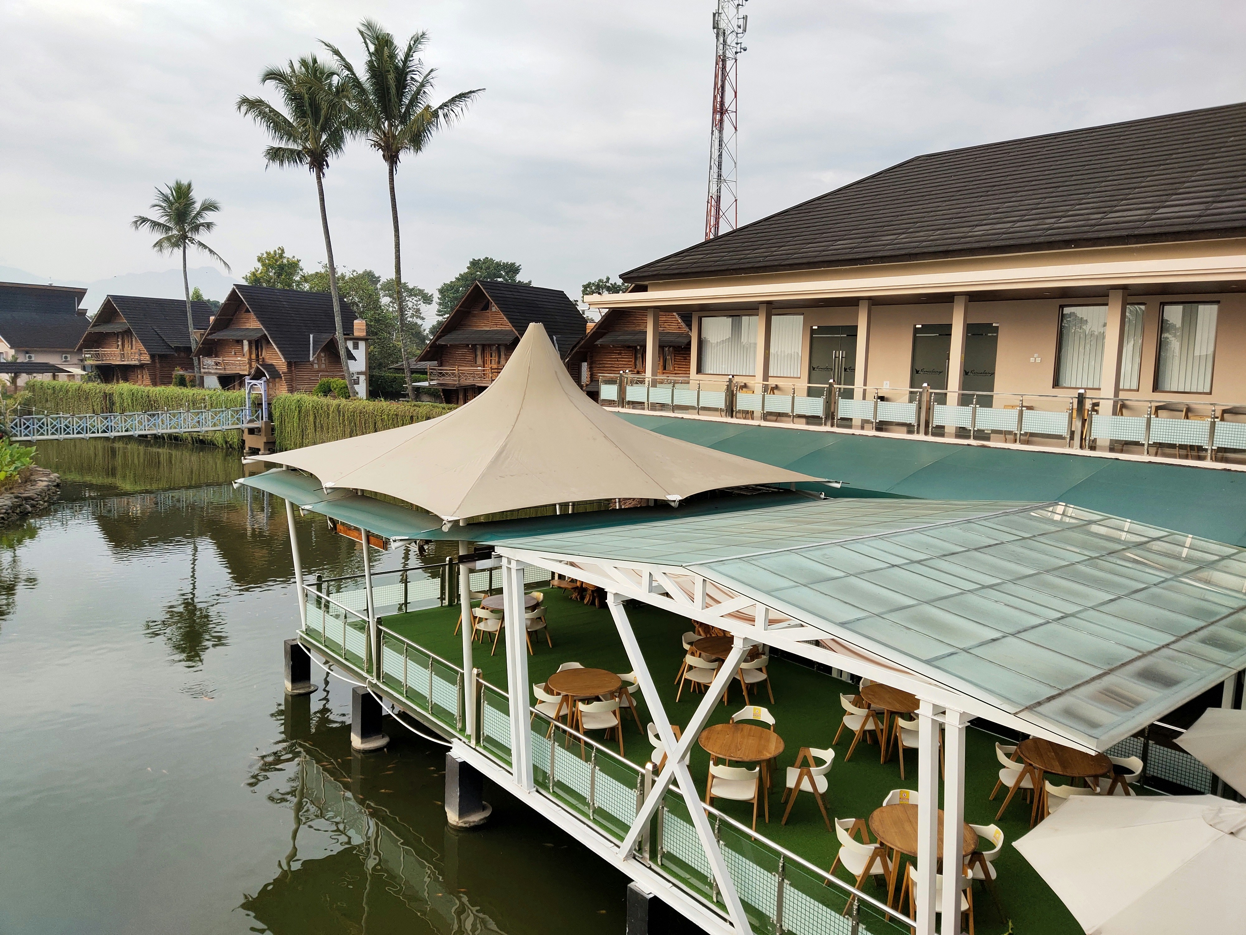 Overwater dining pavilion anchored by palm shadows