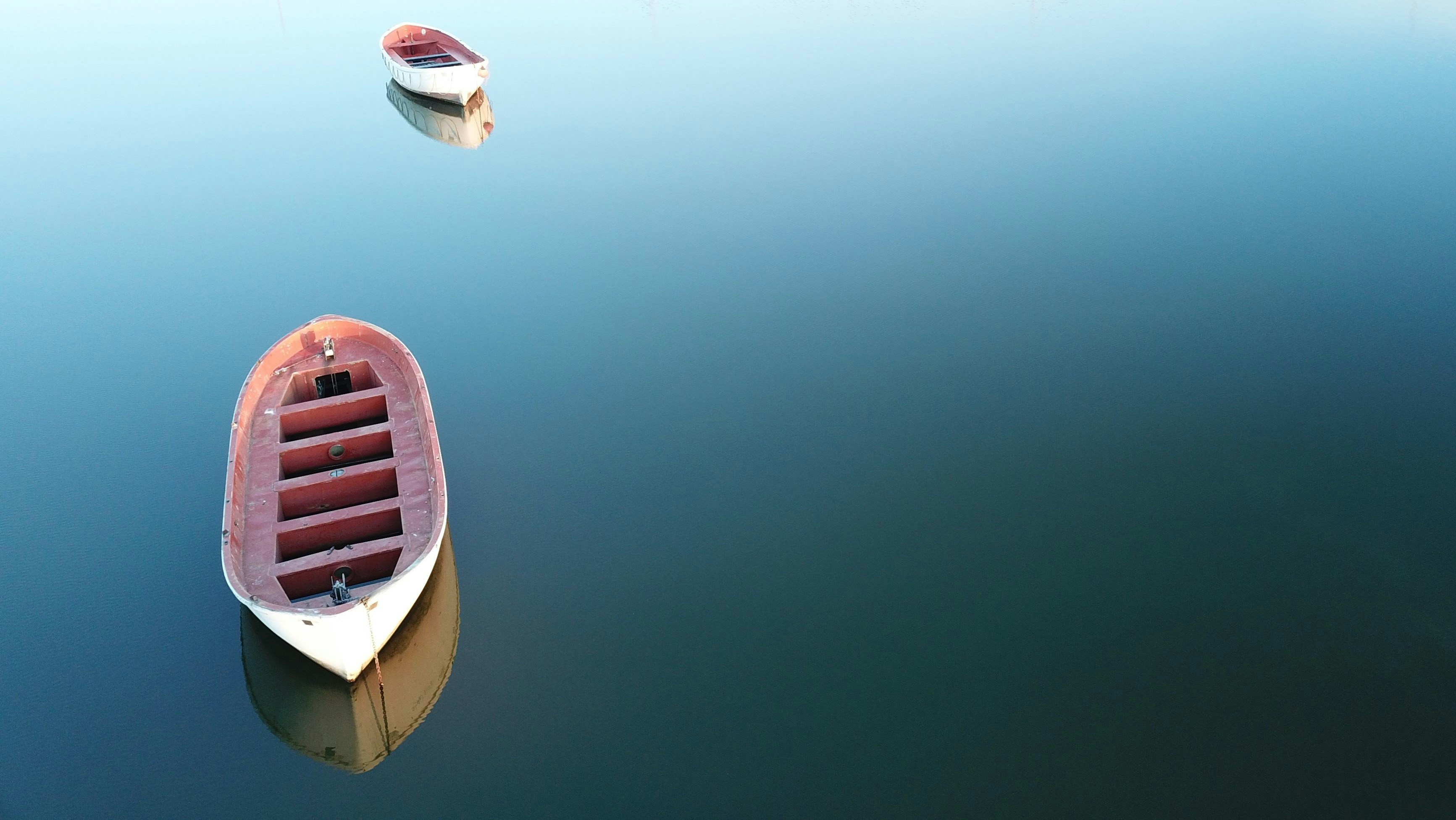 Red Rowboats on a Glassy Lake: An Aerial Study in Serenity