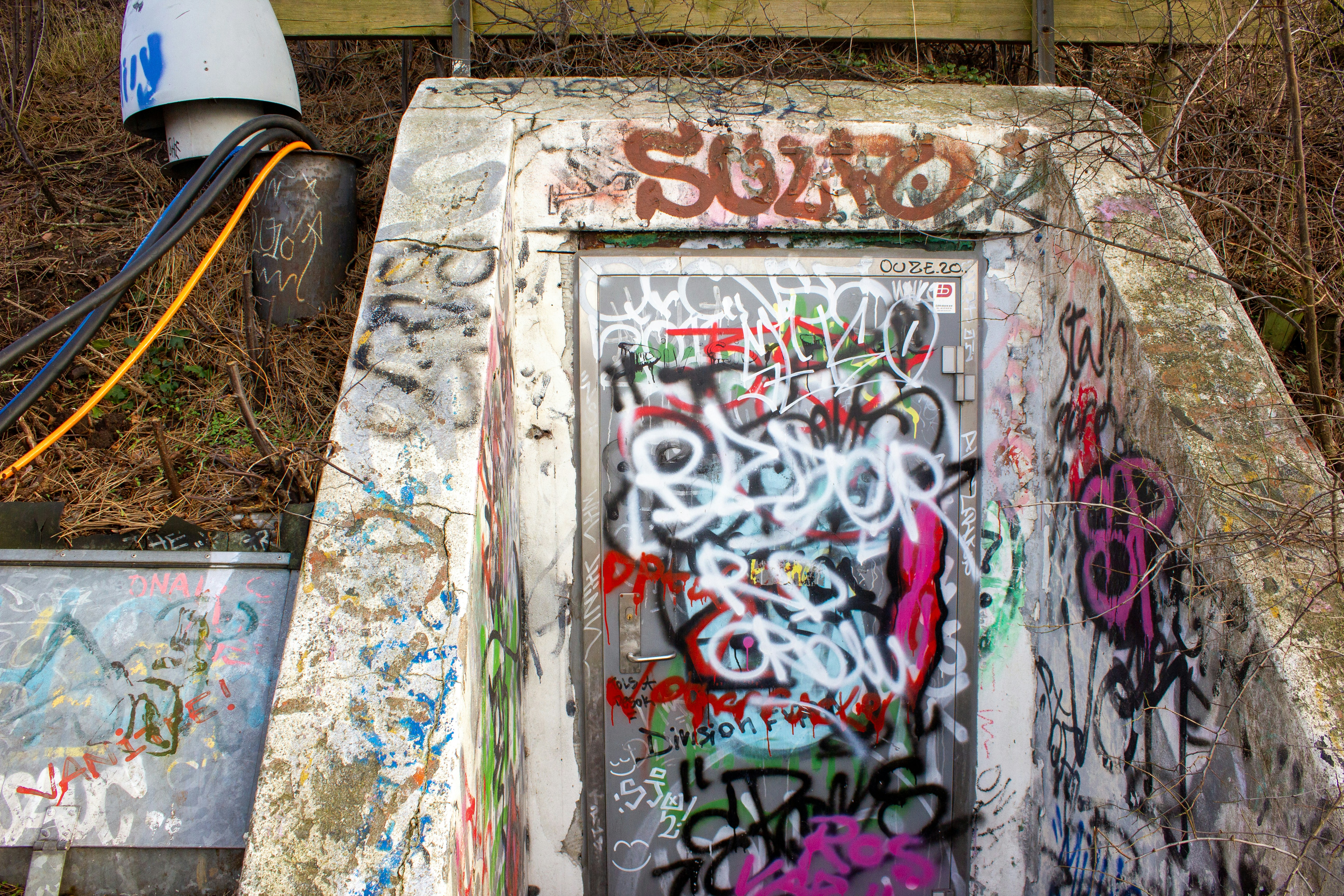Graffiti on a concrete structure near a trash can photo – Free Grafitti ...
