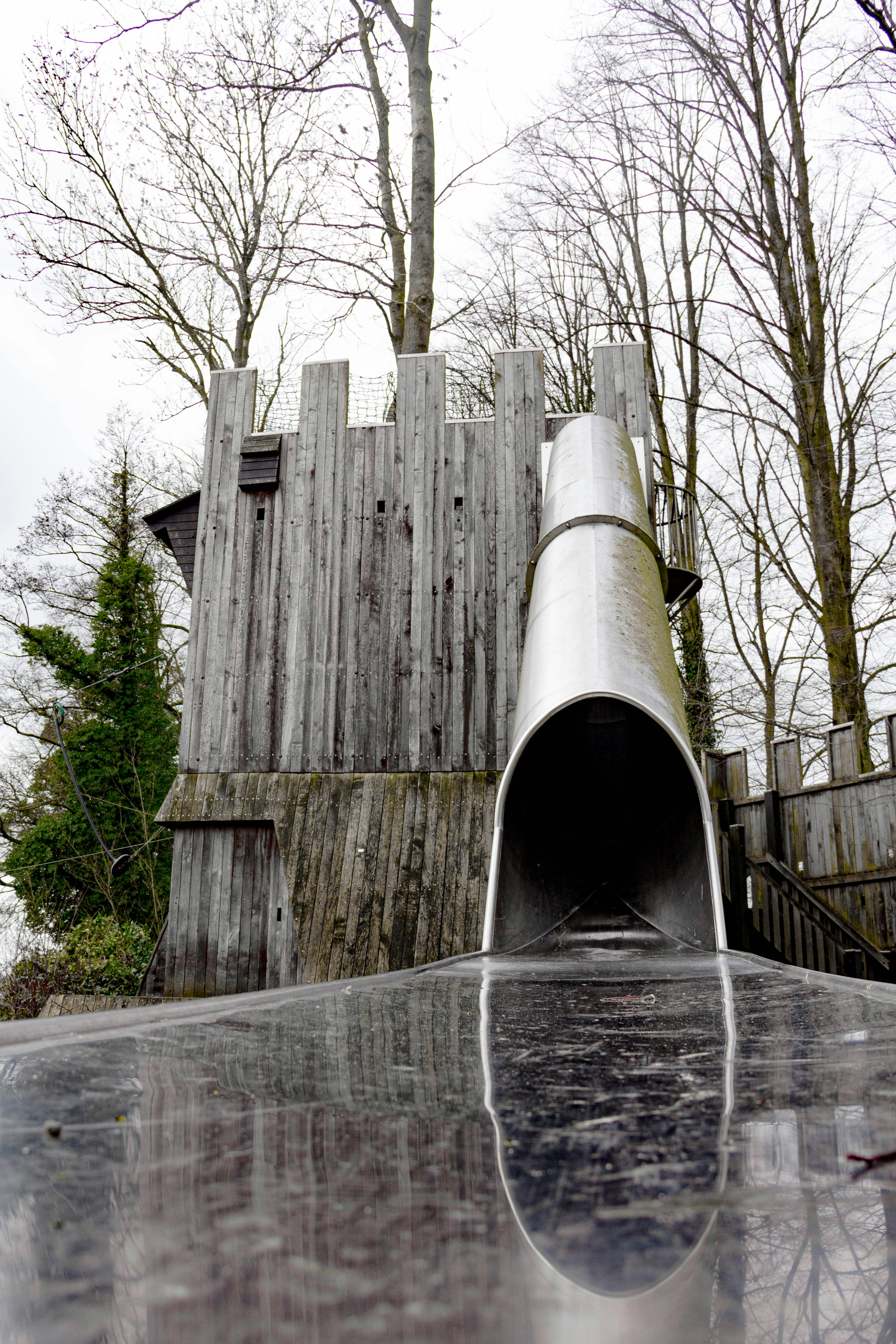 Metal Tube Slide Emerging from Weathered Fort Wall