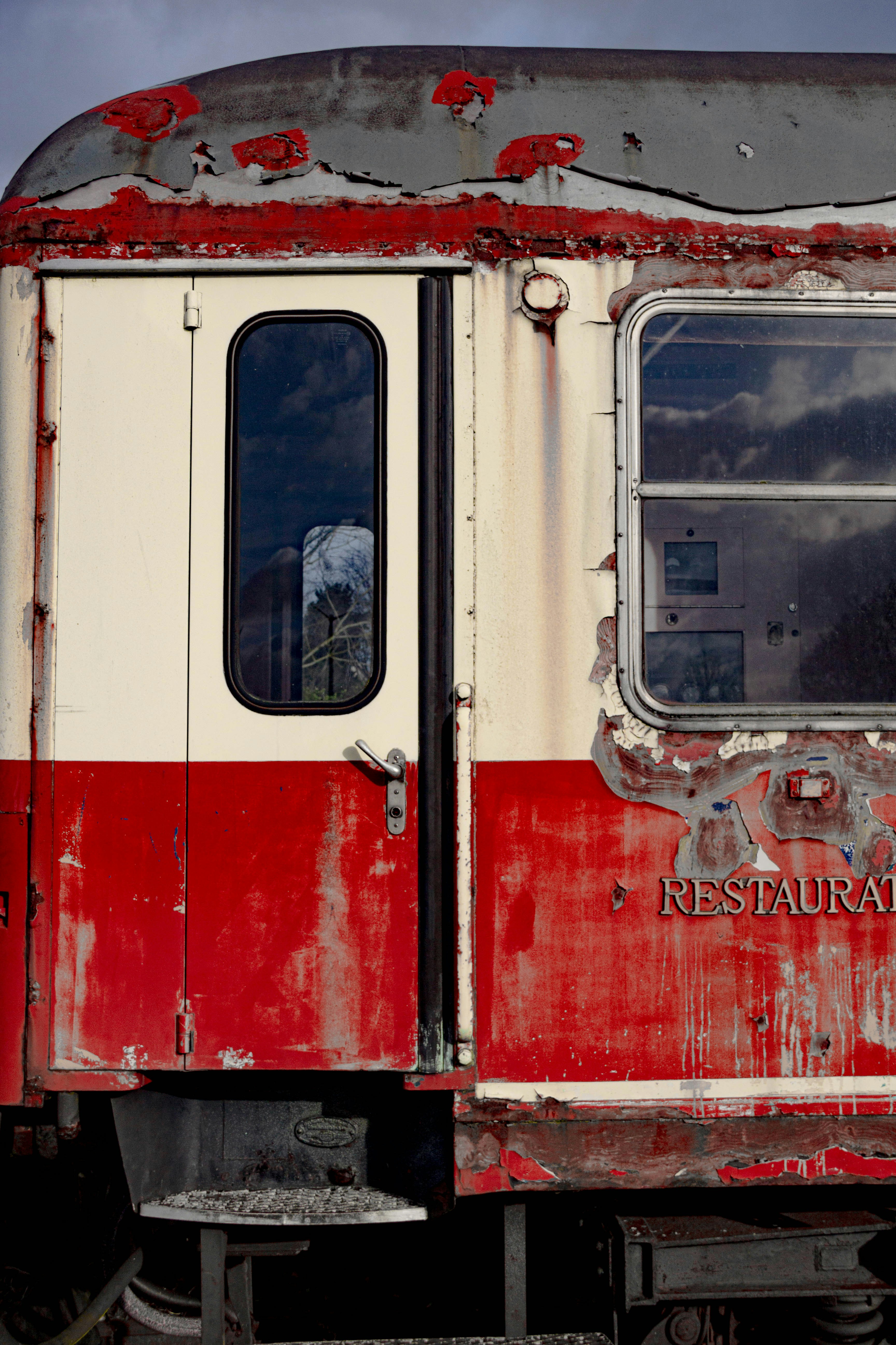 A red and white train car sitting on the tracks photo – Free ...
