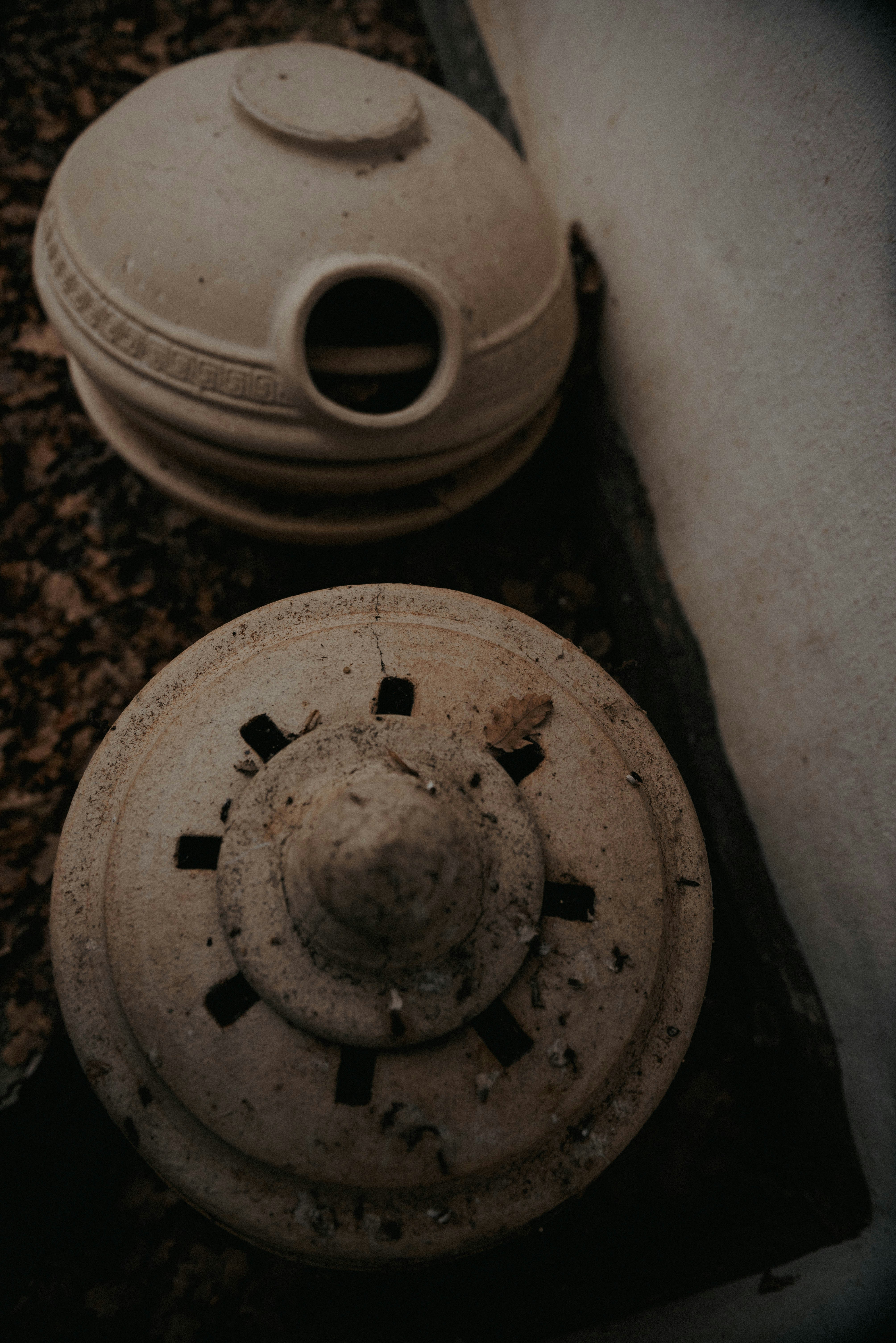 Dust-Swept Ceramic Lids Rest in a Shadowed Corner