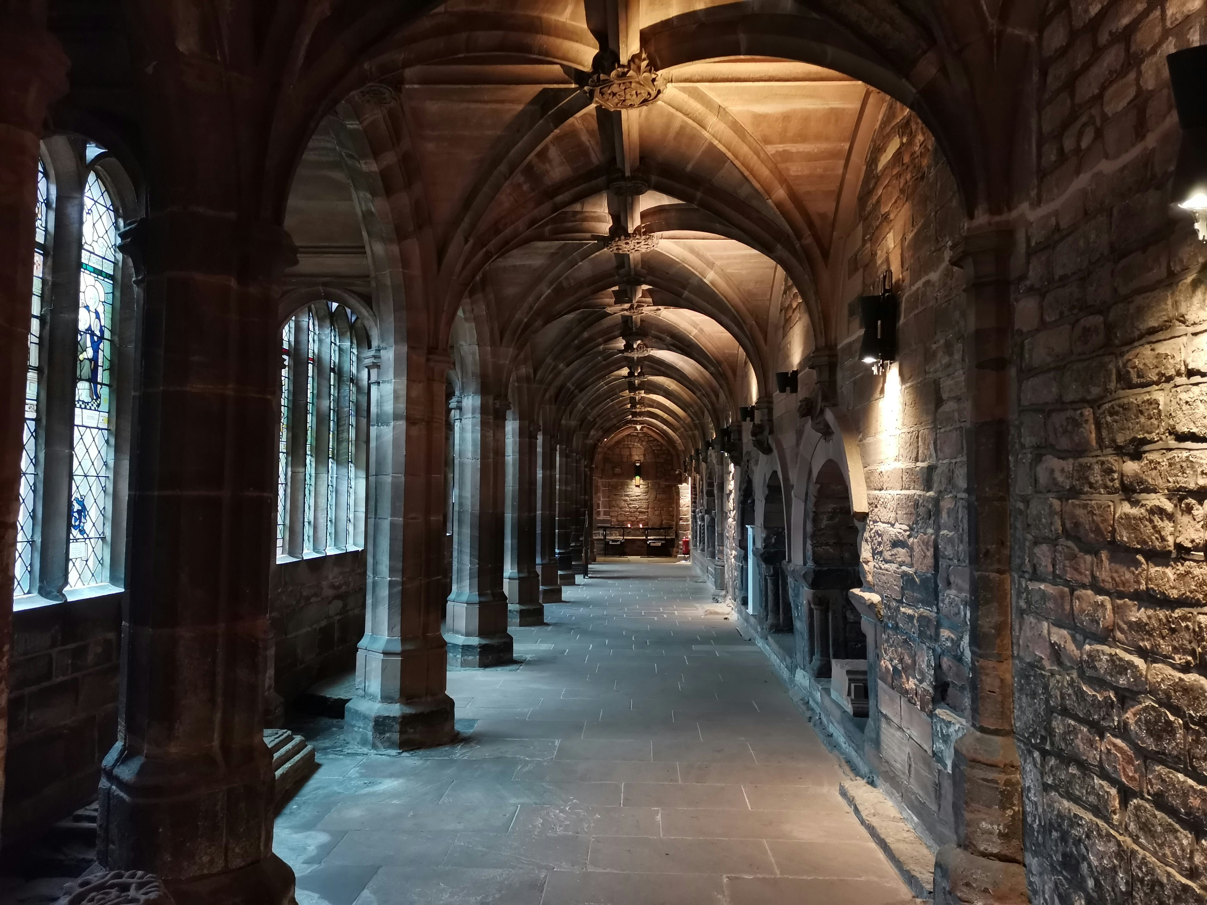 A long hallway with stone walls and arches photo – Free Chester Image ...