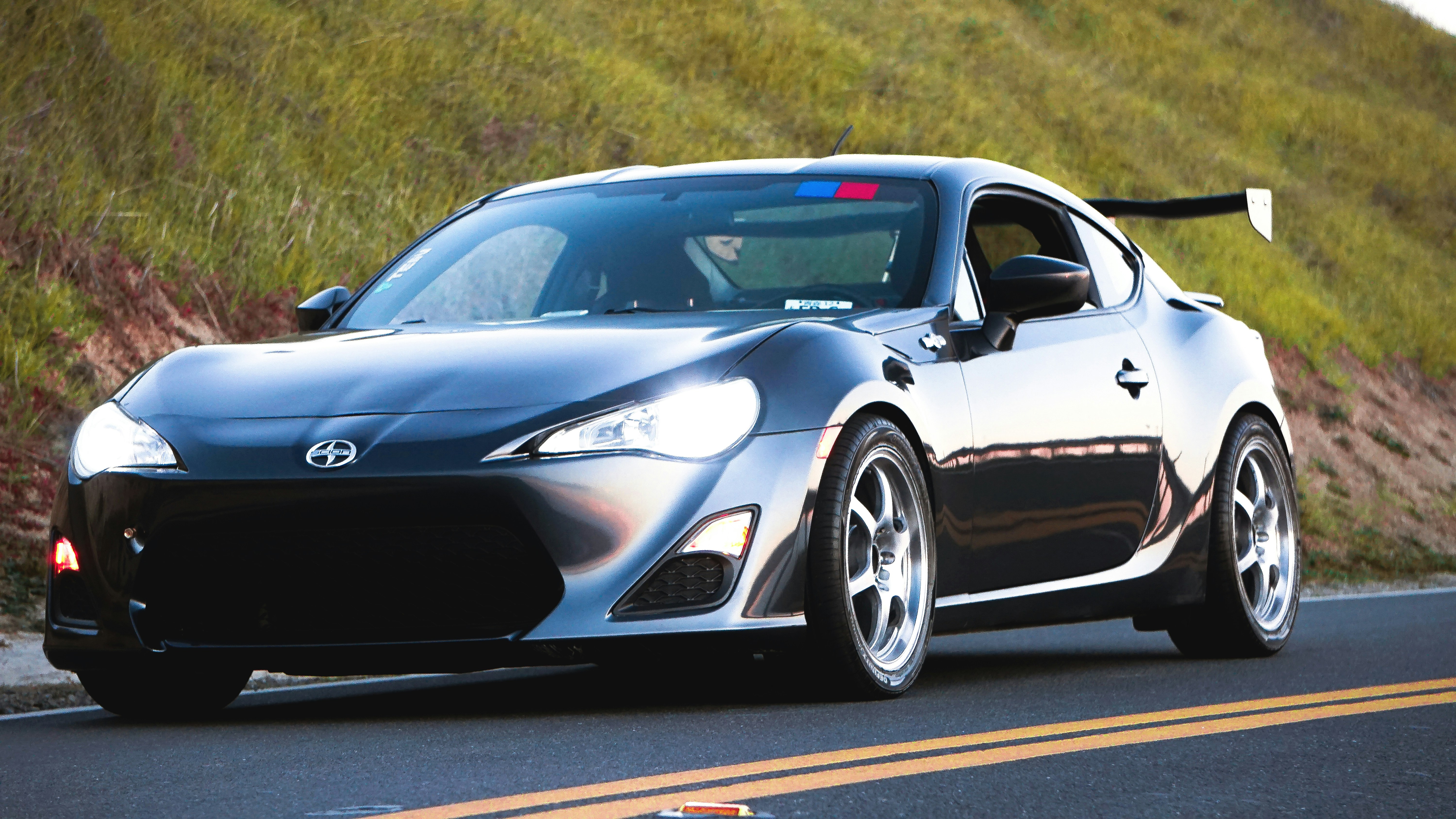 A gray sports car driving down the road photo – Free Sports car Image ...