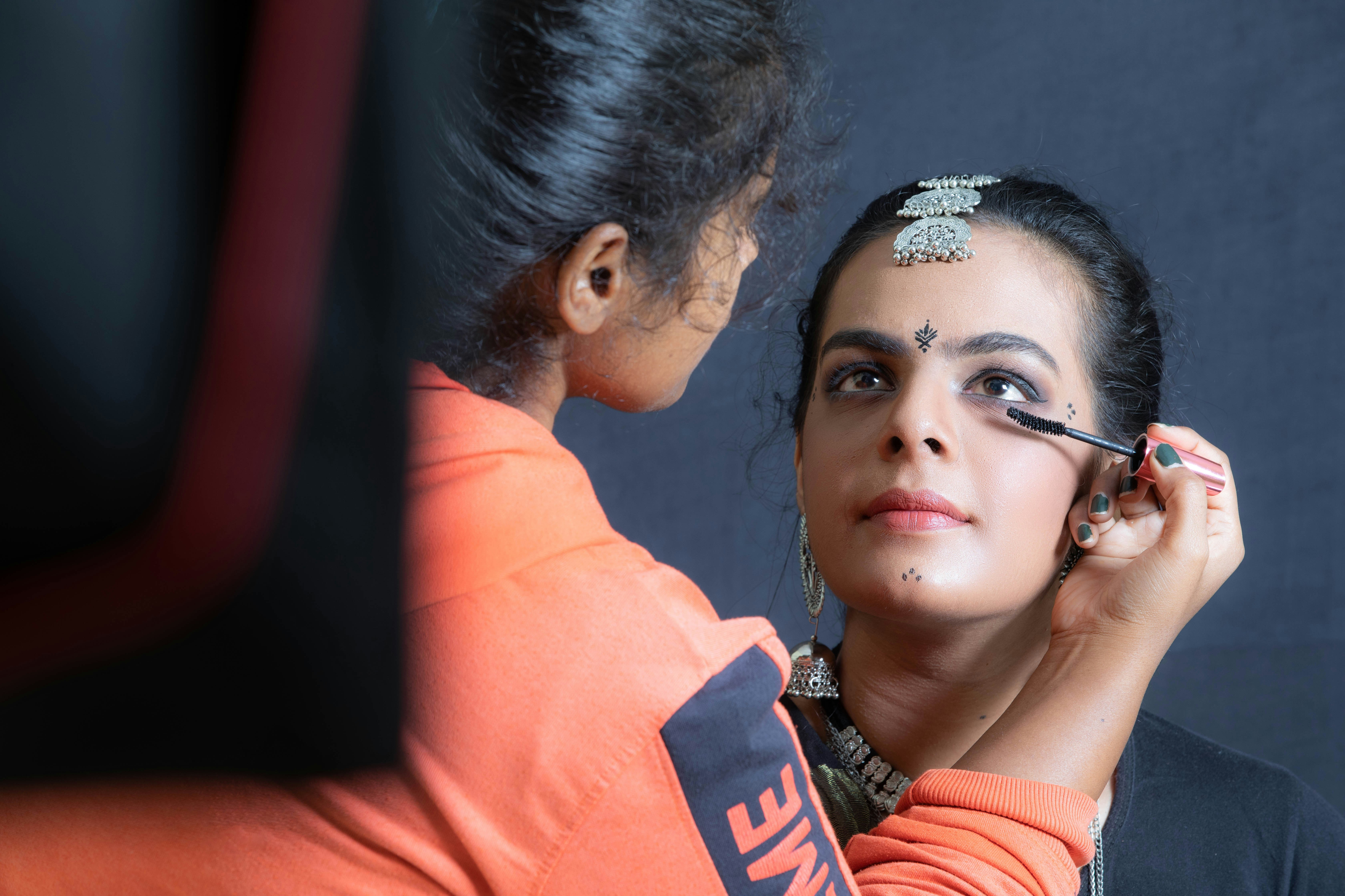 A woman is doing makeup on her face photo – Free Indian model Image on ...