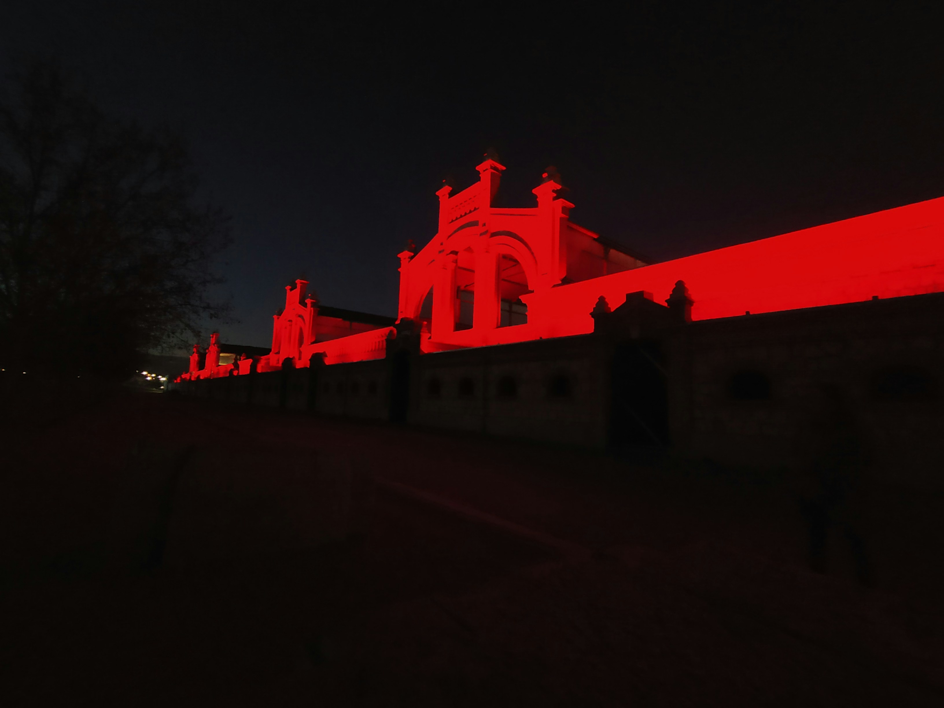 Crimson Lumen Over a Historic Gate