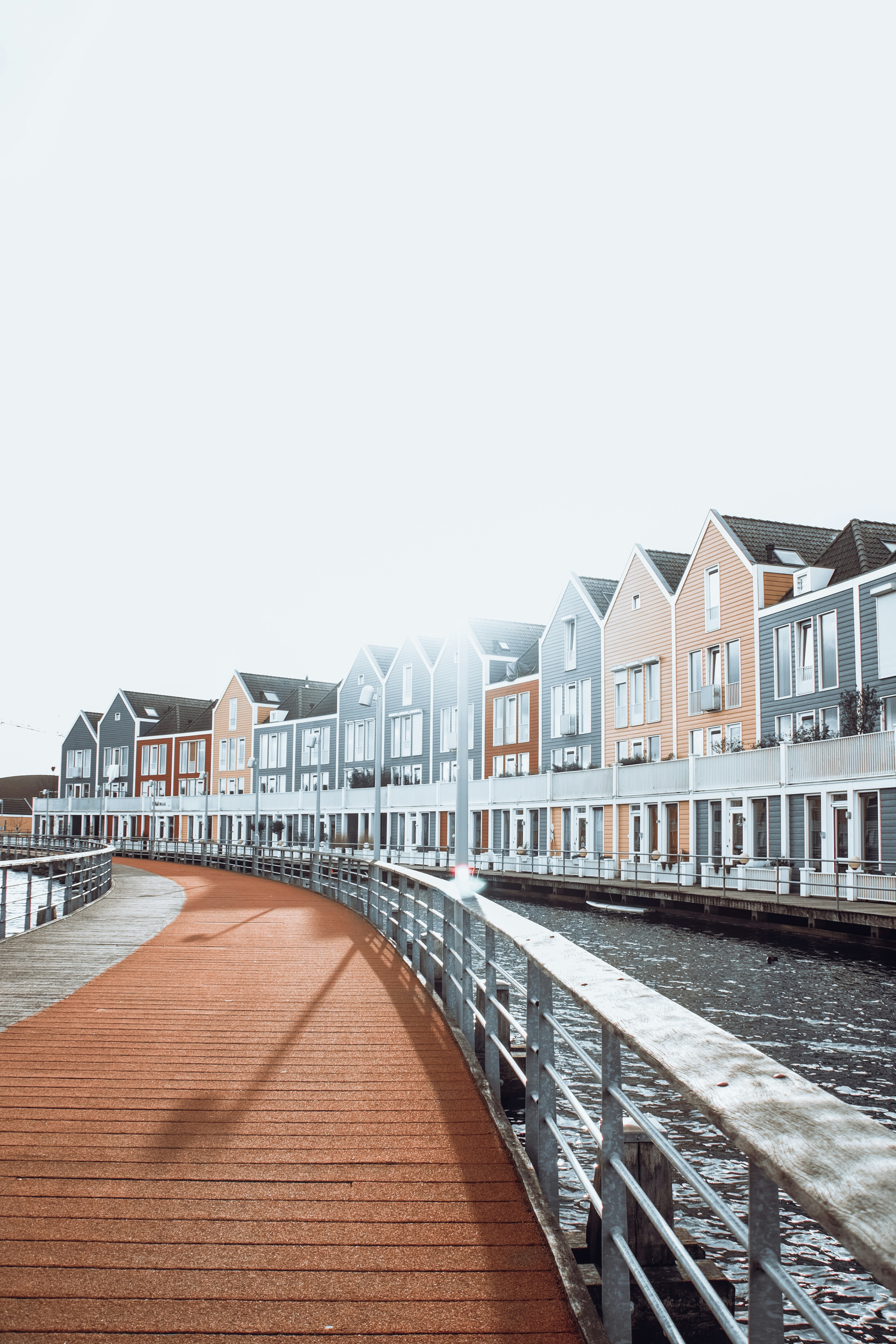 Pastel Row Along a Curved Riverside Boardwalk
