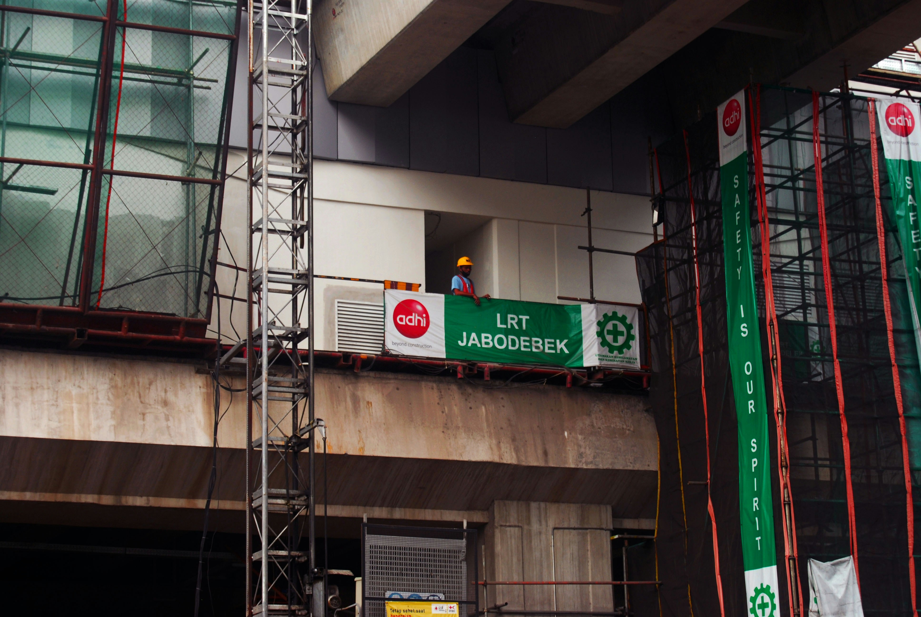 A man standing on a scaffold next to a building photo – Free Jakarta ...