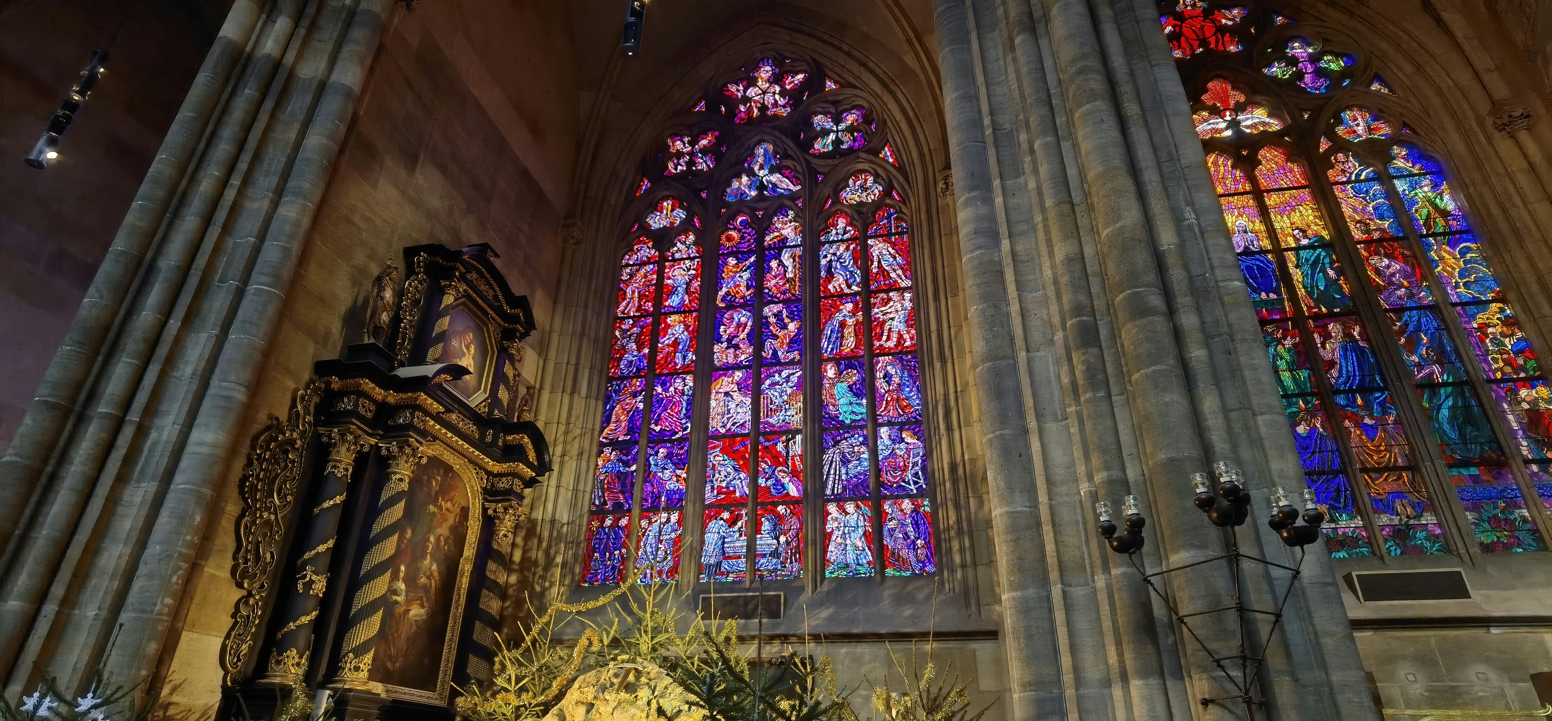 Vibrant stained glass windows casting colorful patterns across the interior of a grand cathedral, highlighting intricate details of the architecture.