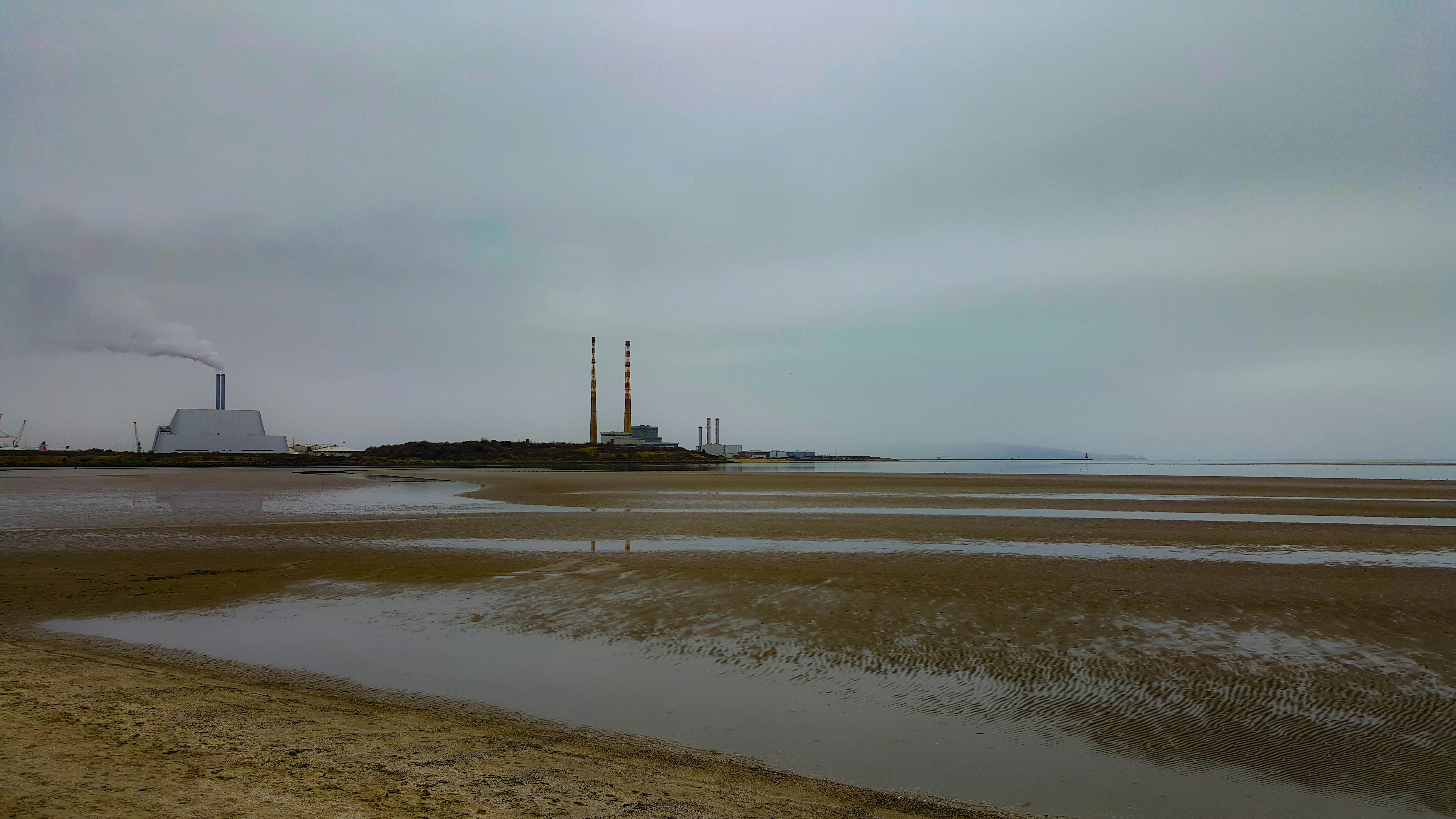 A factory with smoke coming out of it near a body of water photo – Free ...