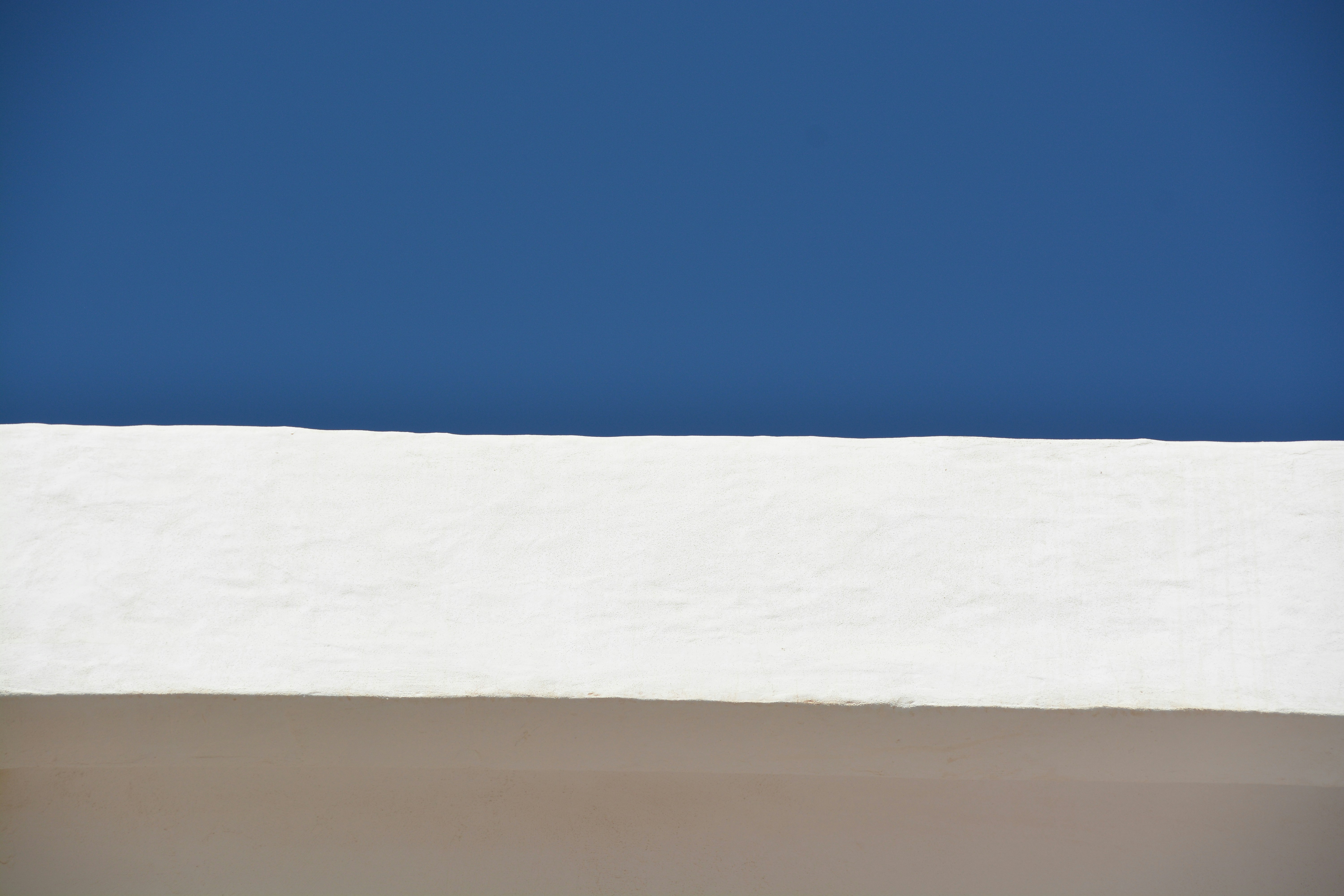 White wall against a deep blue sky creating a stark contrast.