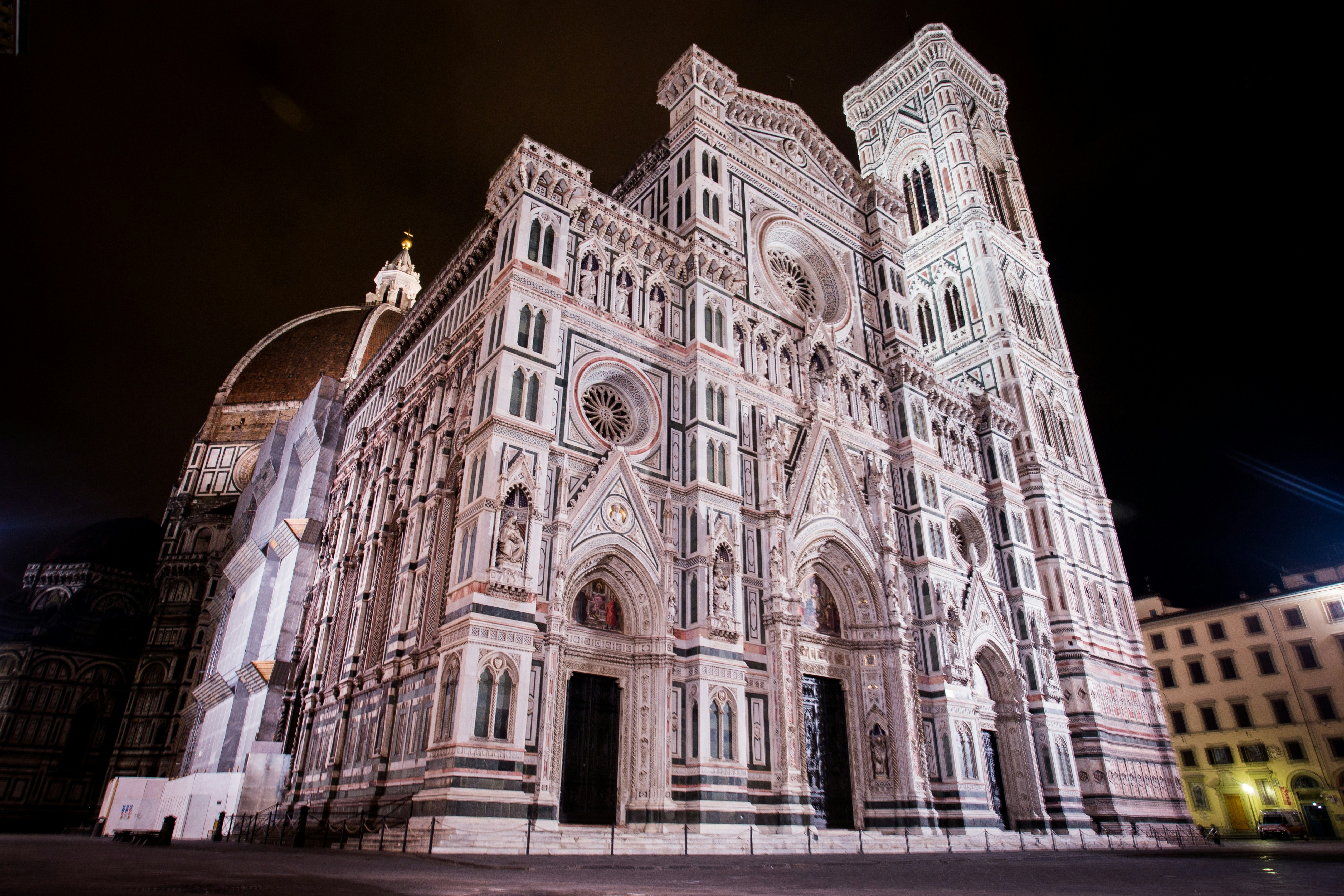 Gothic architecture of the Florence Cathedral illuminated against a night sky, showcasing intricate details and vibrant colors.