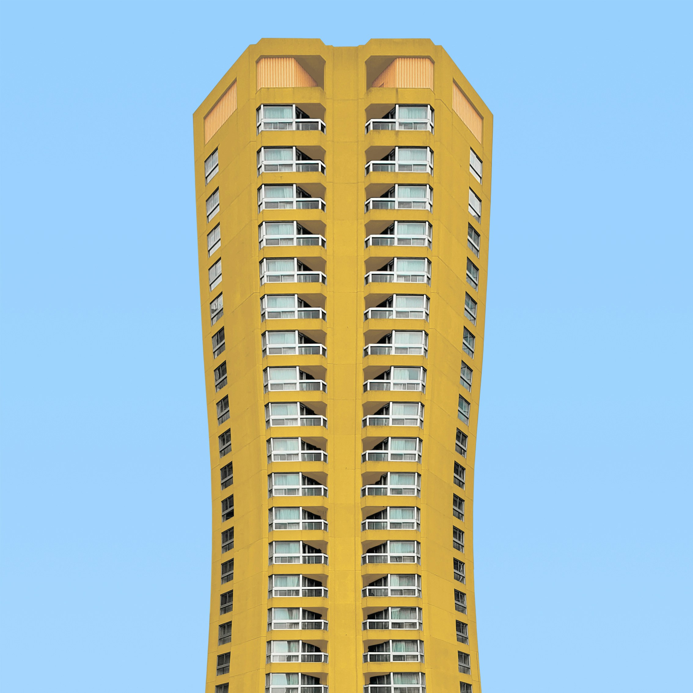 A modern yellow skyscraper with a unique curved design, showcasing its balconies against a clear blue sky.