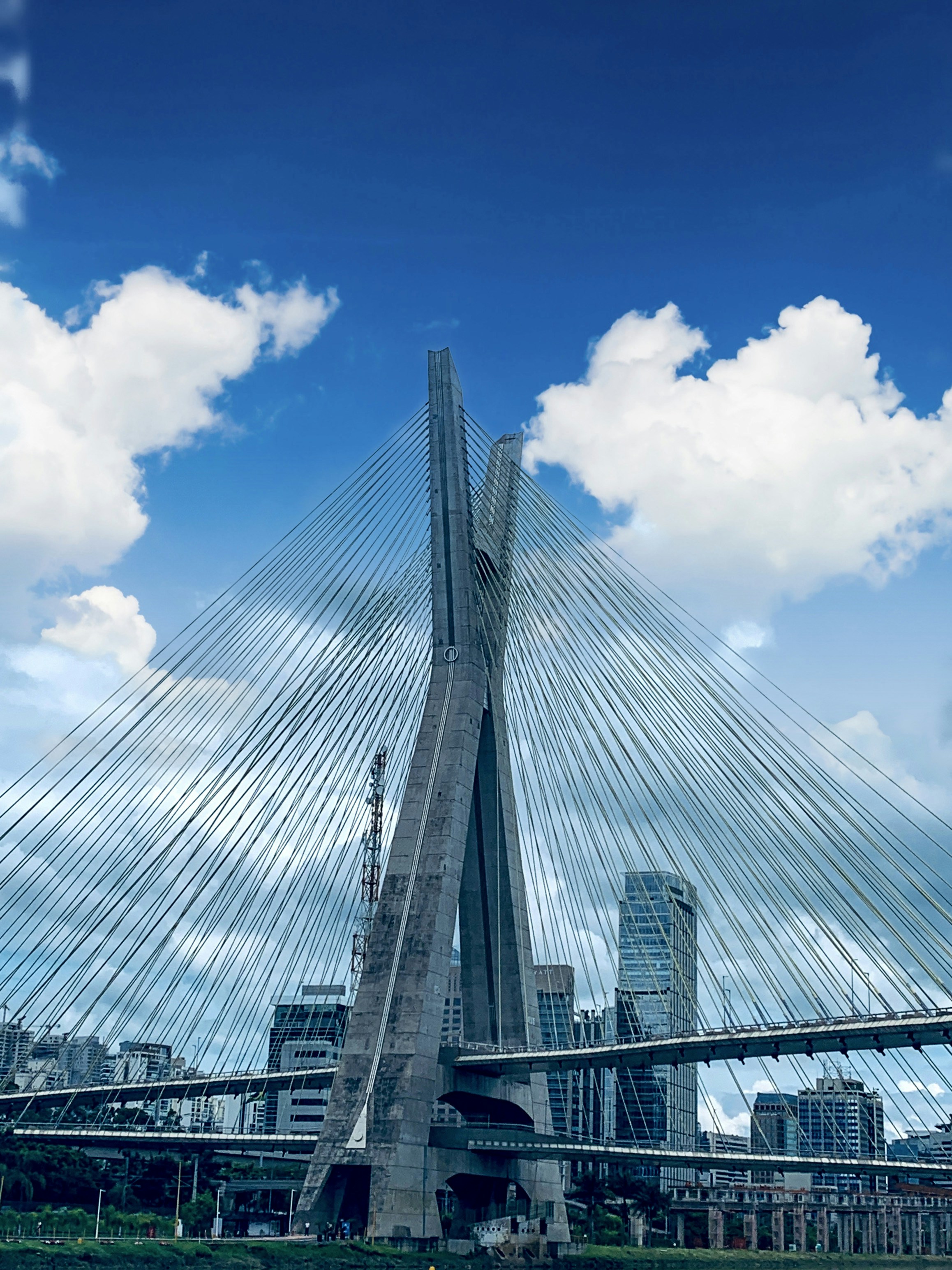 A very tall bridge with a very tall building in the background photo ...