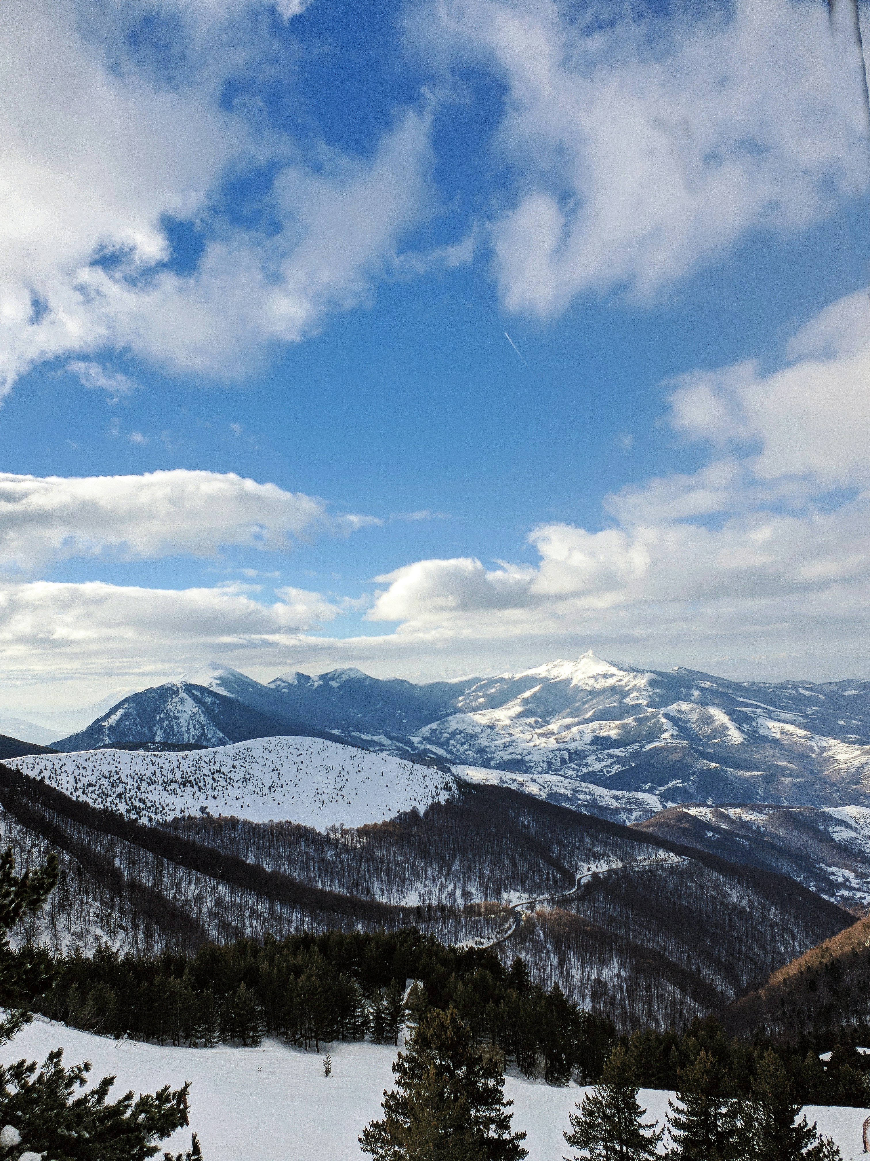 a view of a snowy mountain range from a ski lift