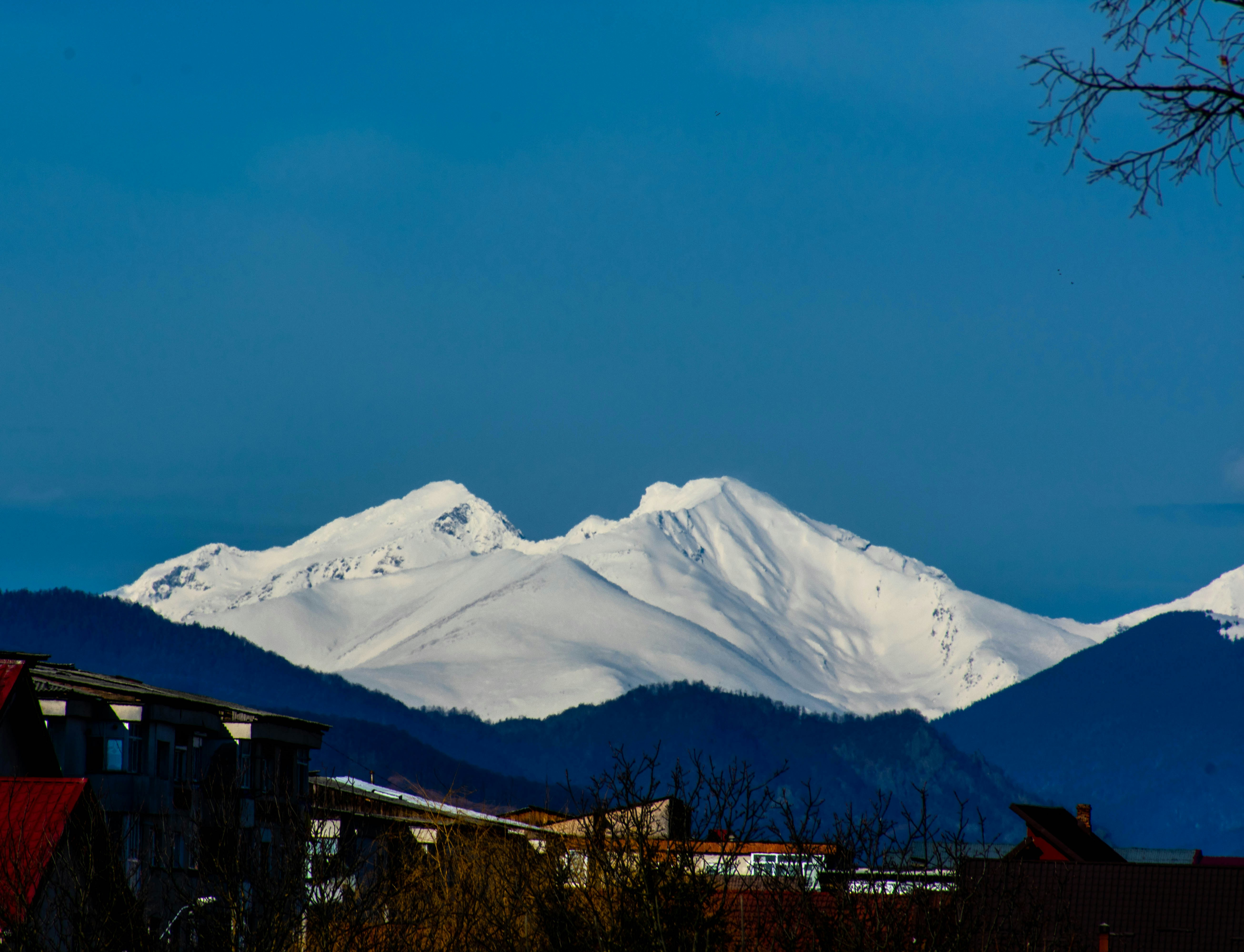 Cerulean Crest: Snowbound Peaks Loom Over a Quiet Town