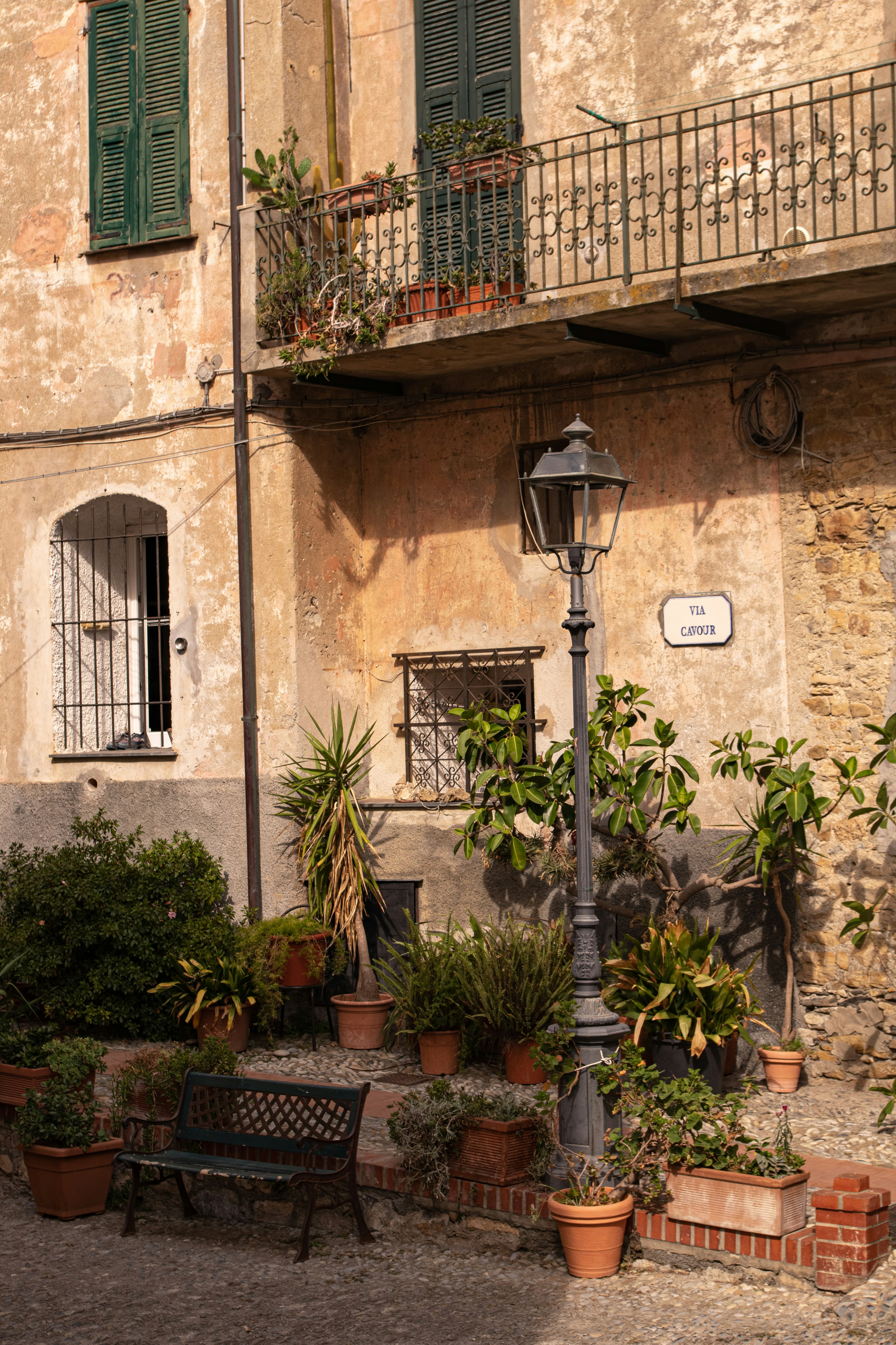 Sunlit Calle: A Rustic Corner with Lantern and Greenery