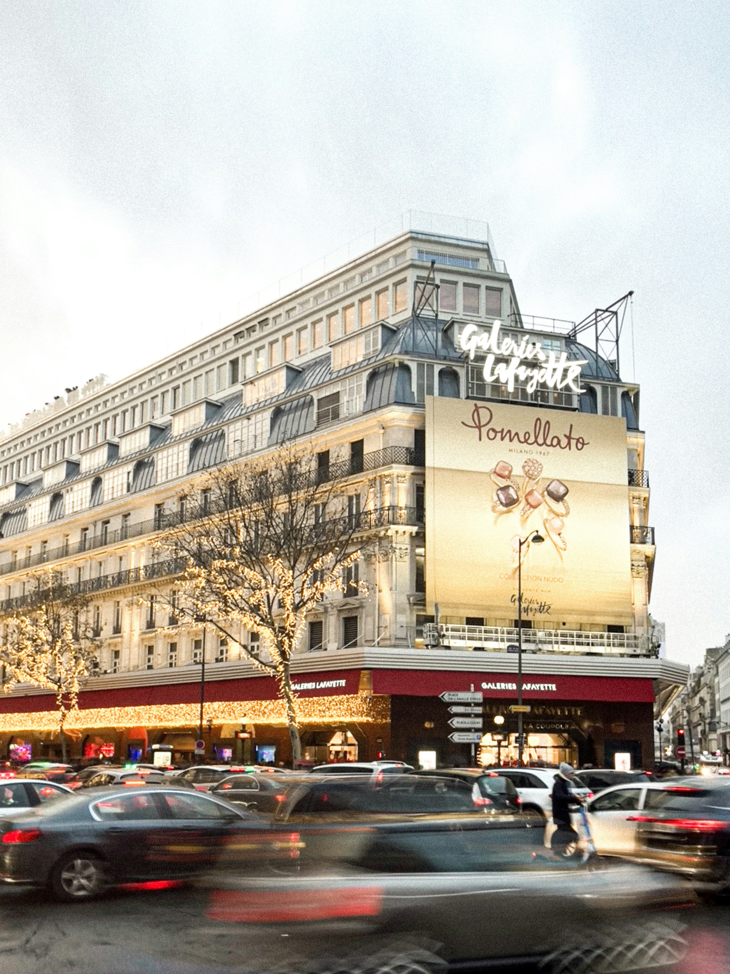 Glow of the Grandeur: Pomellato Signage Above a Bustling Parisian Street