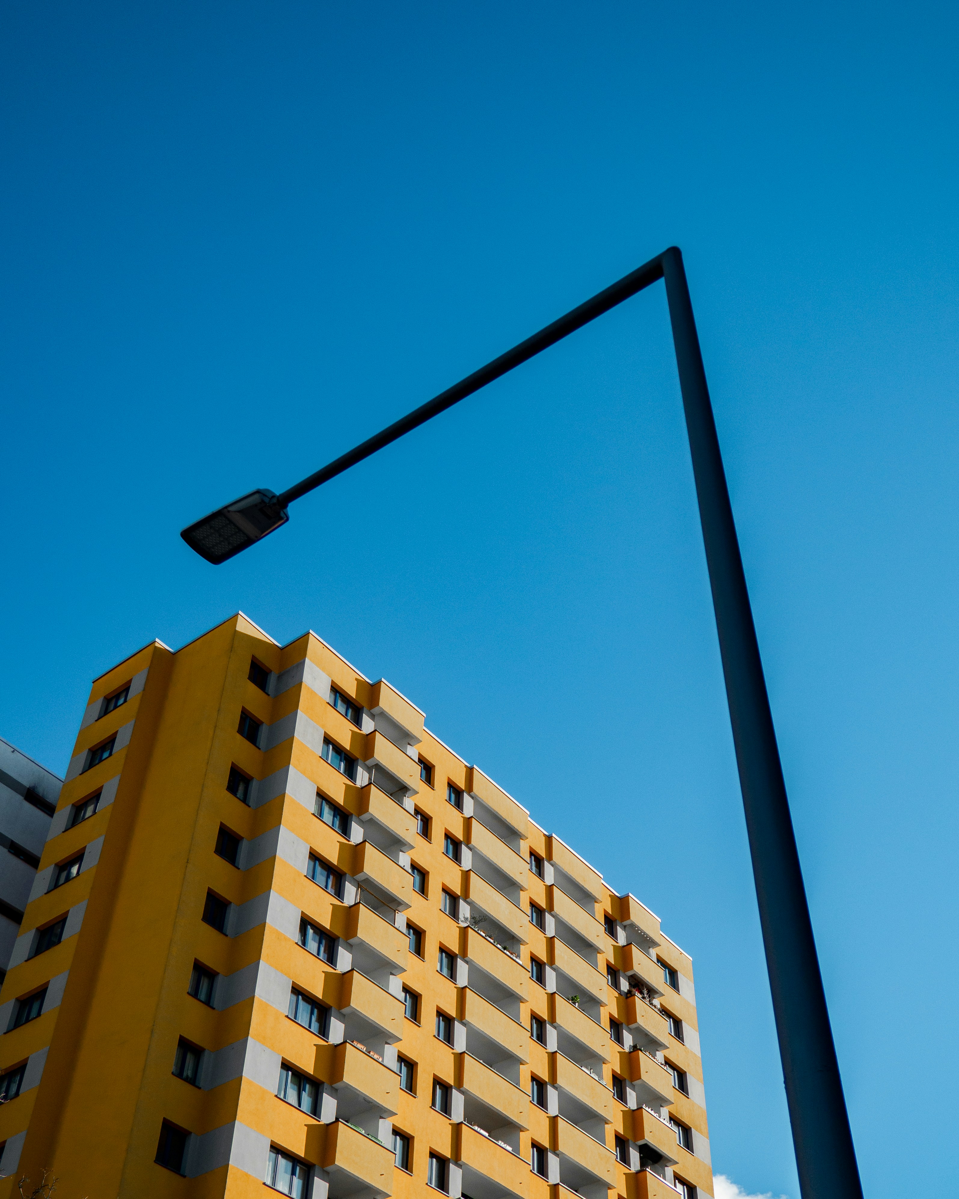 Un grand bâtiment jaune assis à côté d’un lampadaire photo – Photo ...