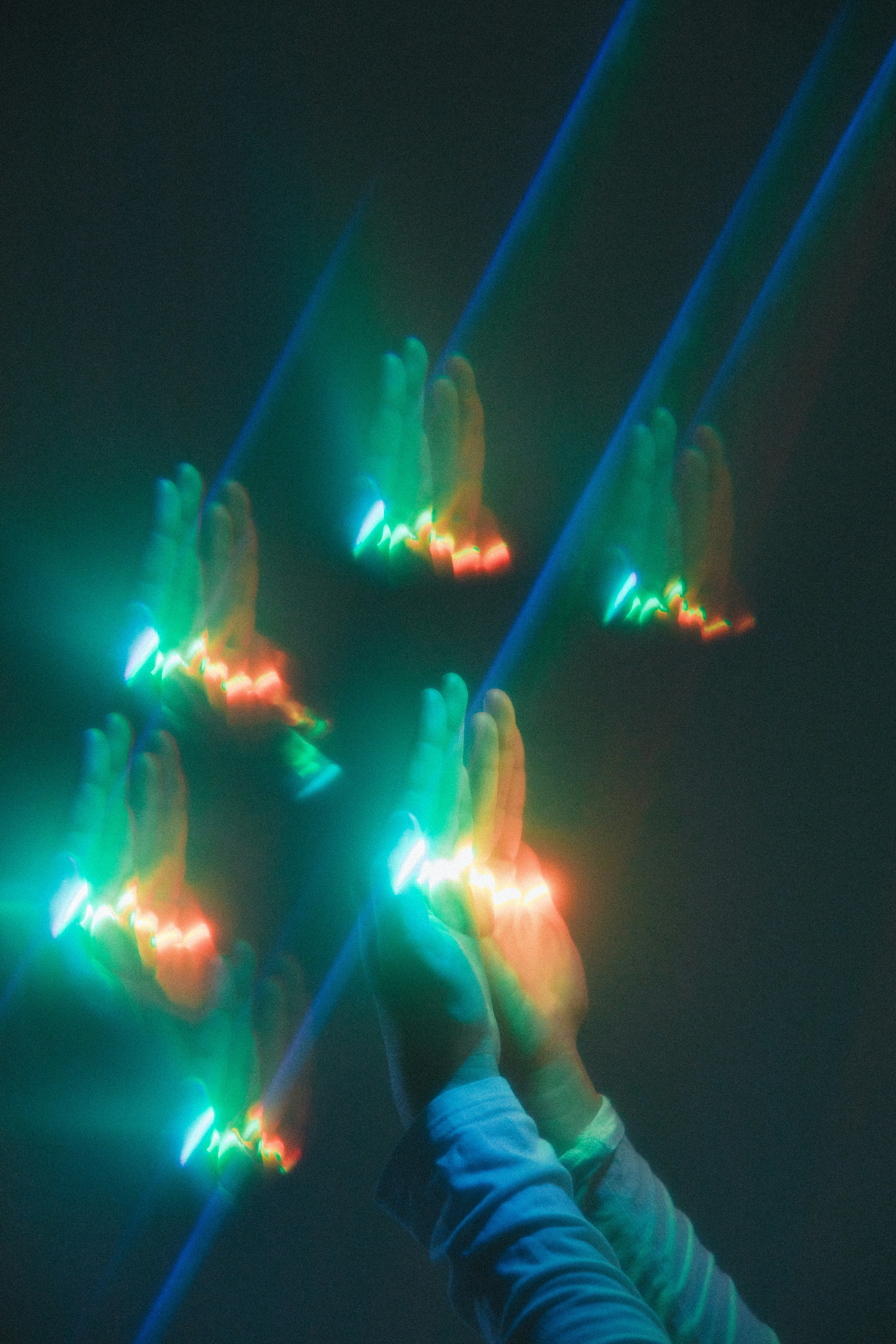 Hands Raised in Neon Light Trails