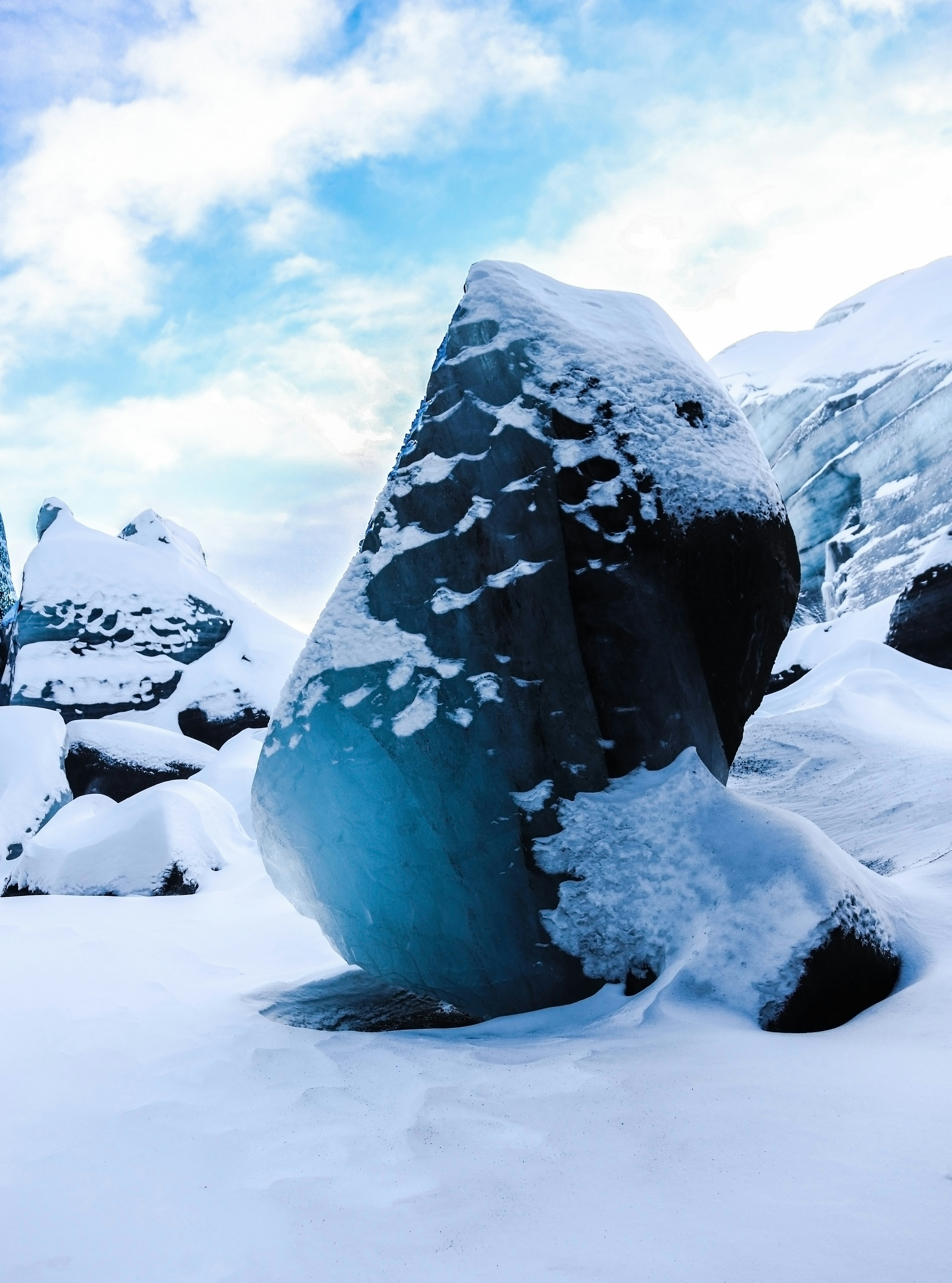 Icebound Monoliths: Snow-clad Boulders Stand Guard Over a Silent Fjord