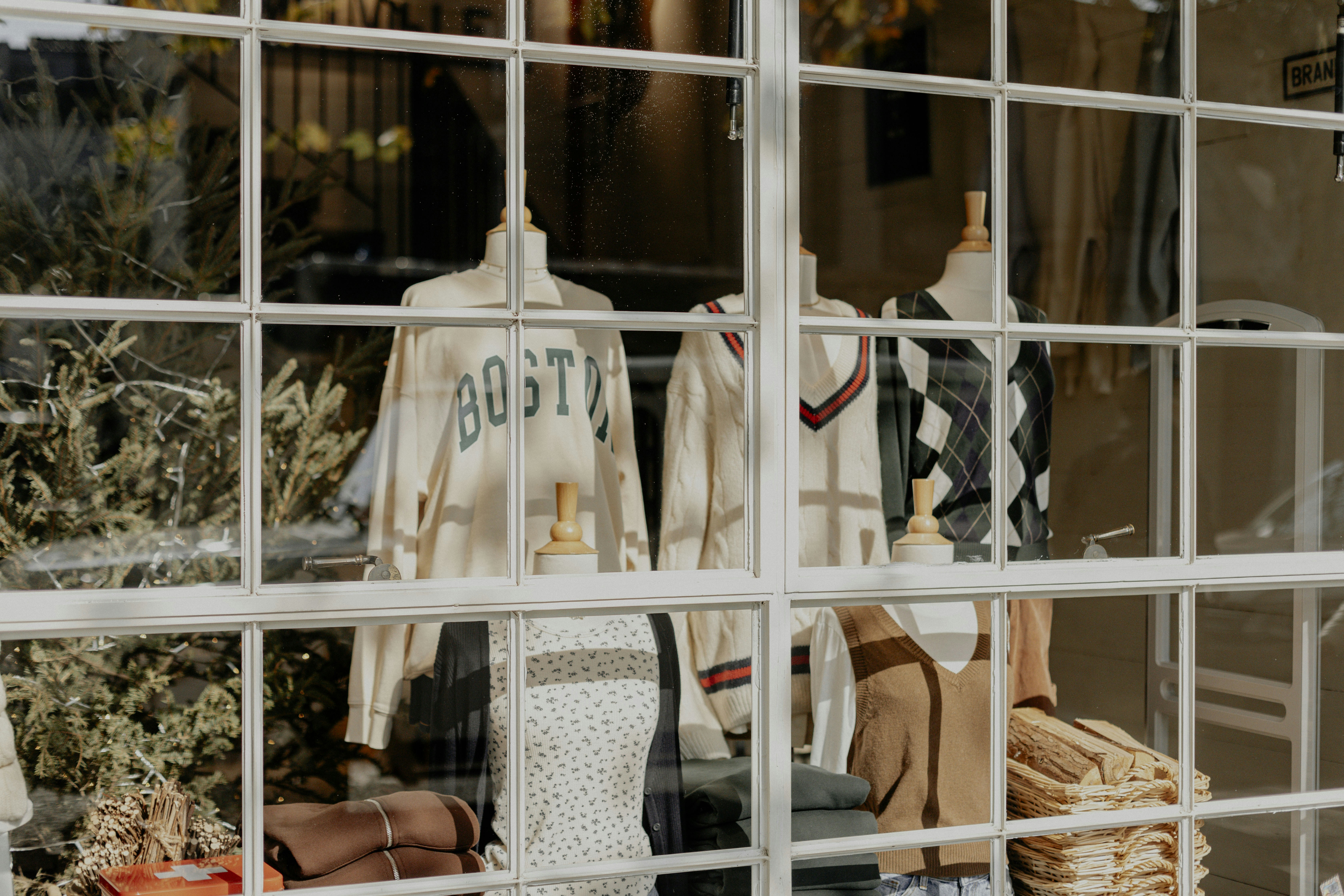 Una ventana con un montón de ropa en exhibición foto – Imagen de Tienda ...