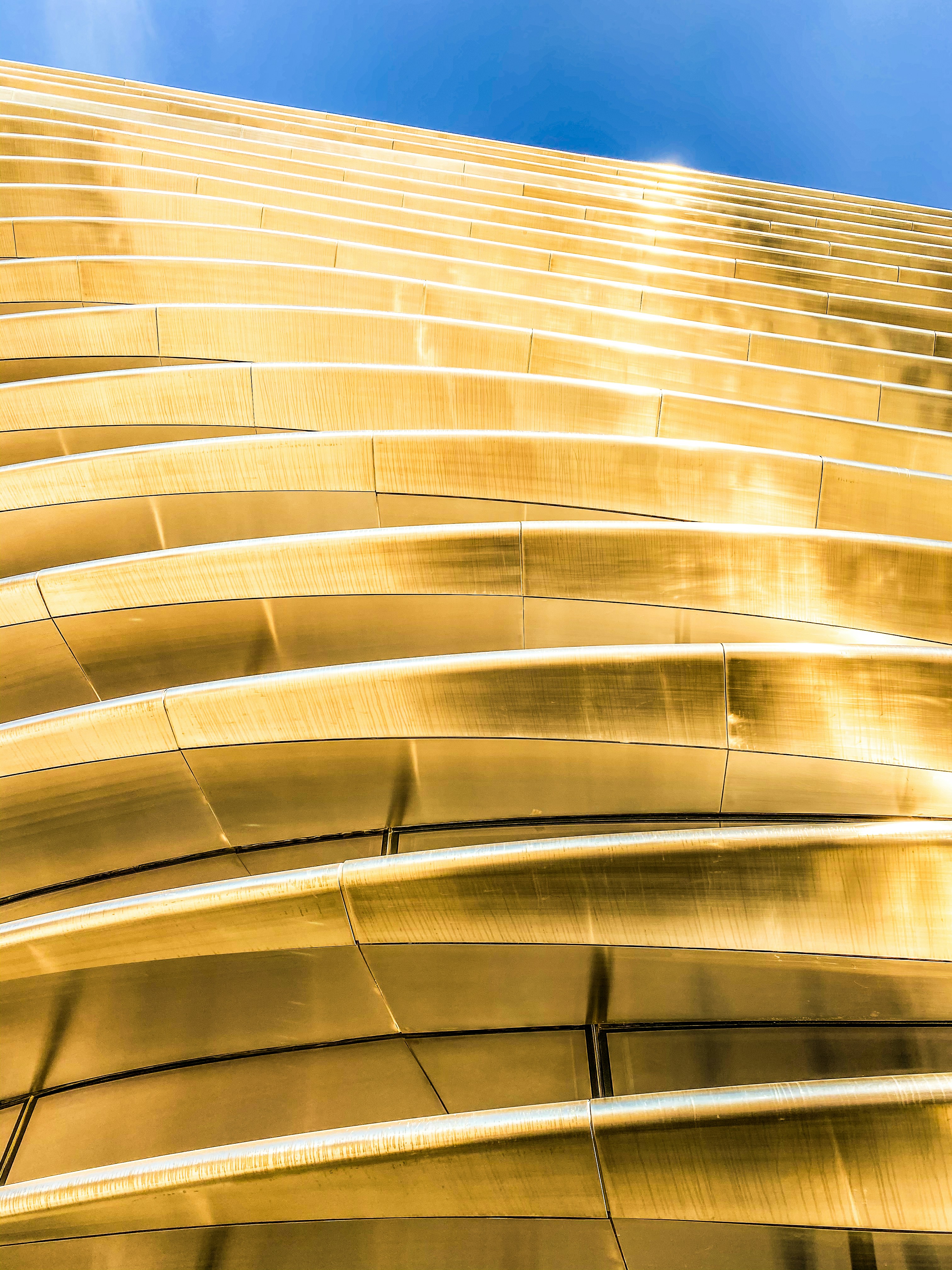 Golden Ribbons of Modern Facade Under a Clear Sky
