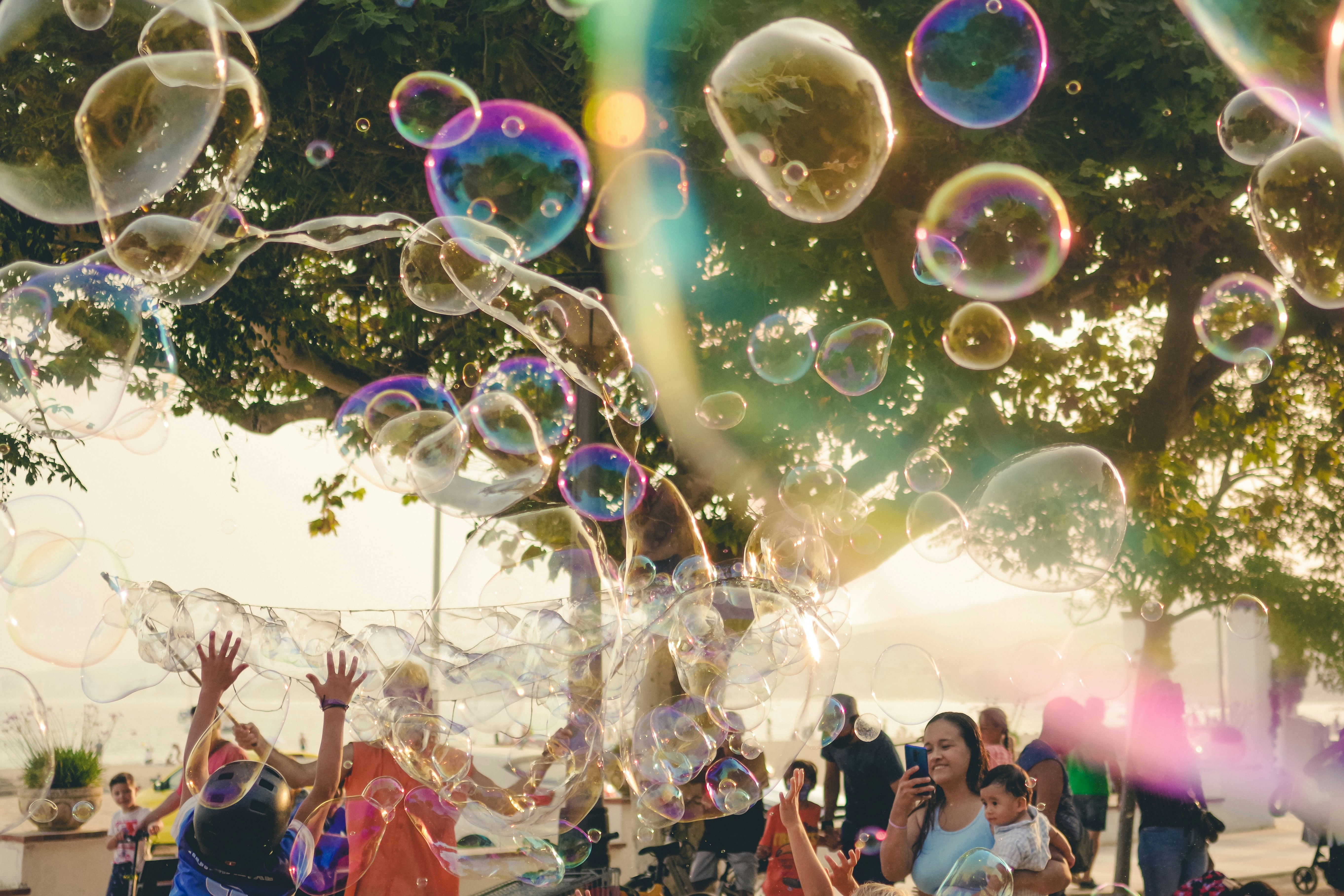 A group of people are blowing soap bubbles photo – Free Fun Image on ...