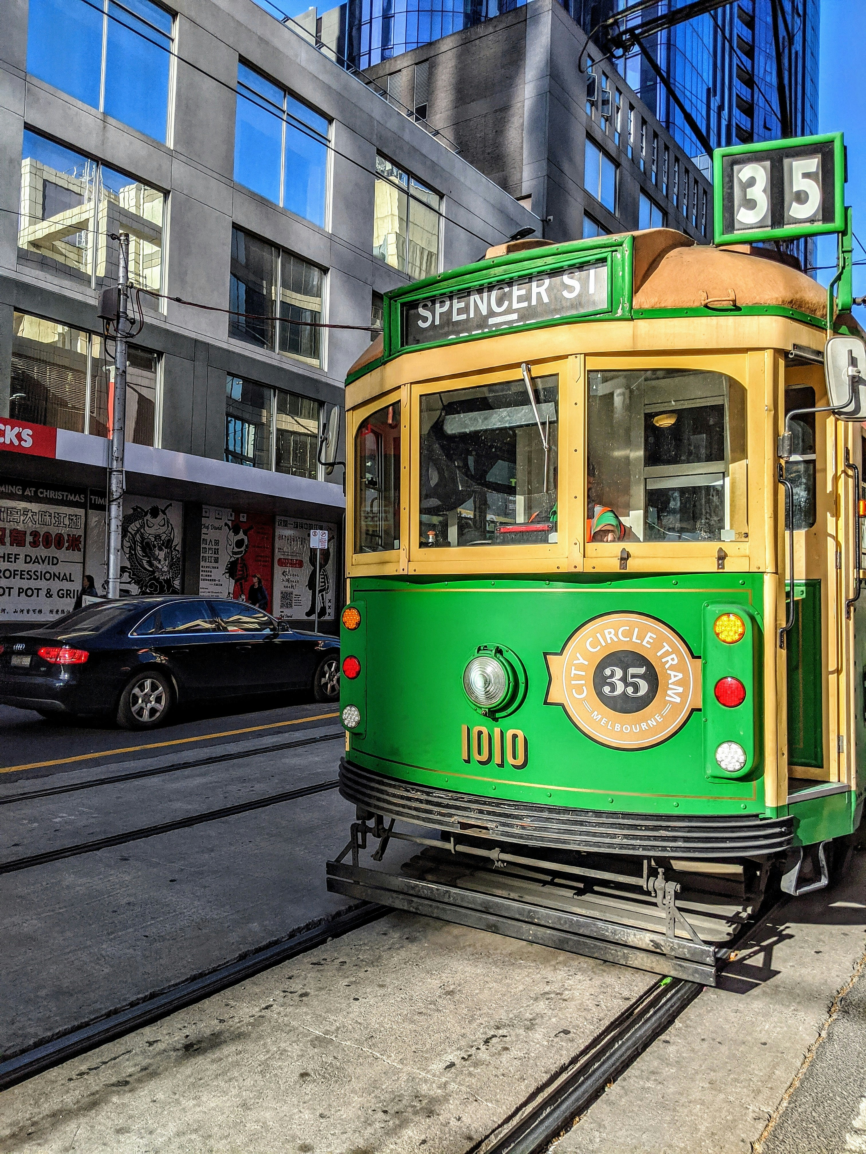 A green and yellow trolley on a city street photo – Free Cbd Image on ...