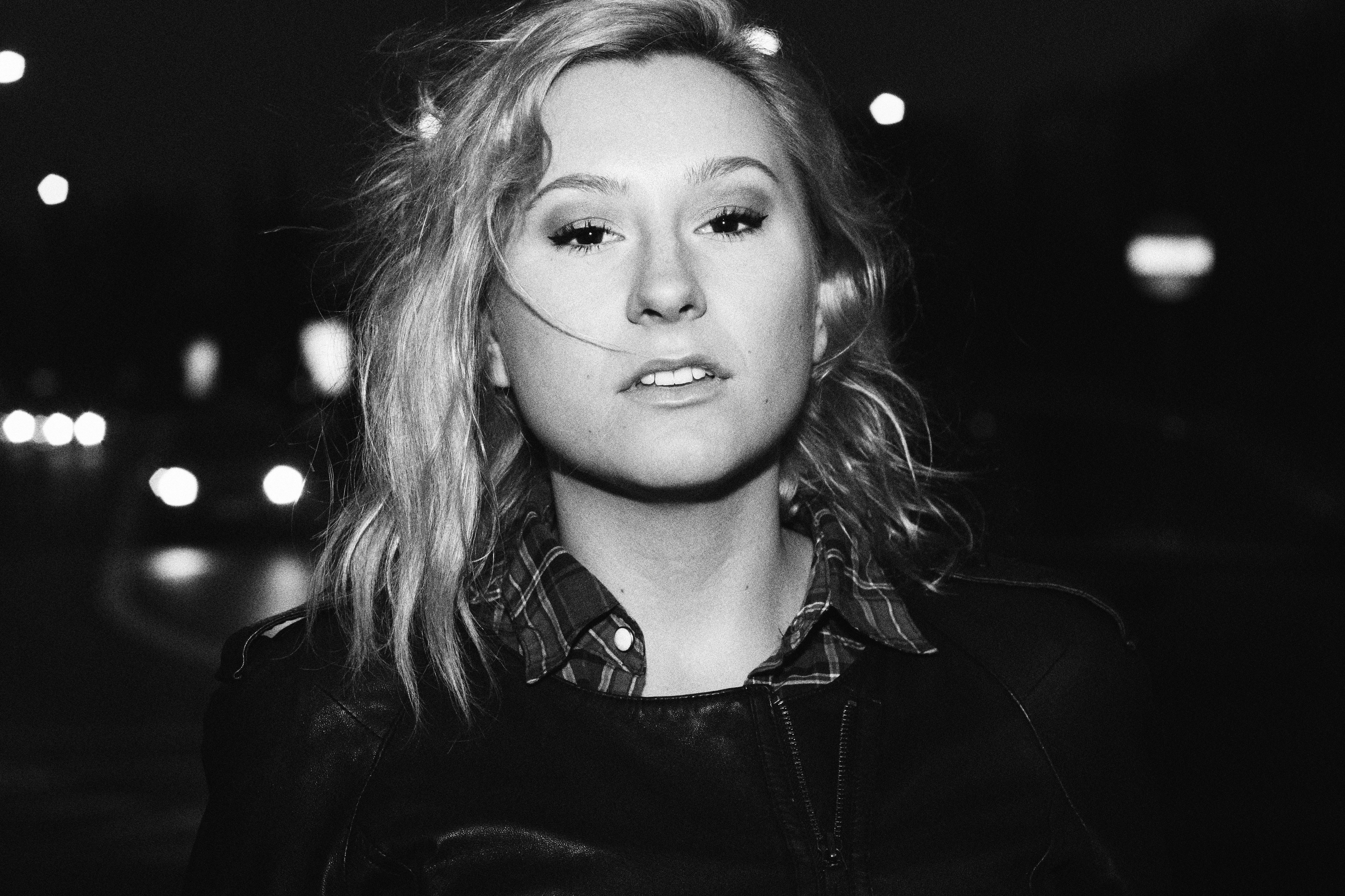 a black and white photo of a woman in a leather jacket