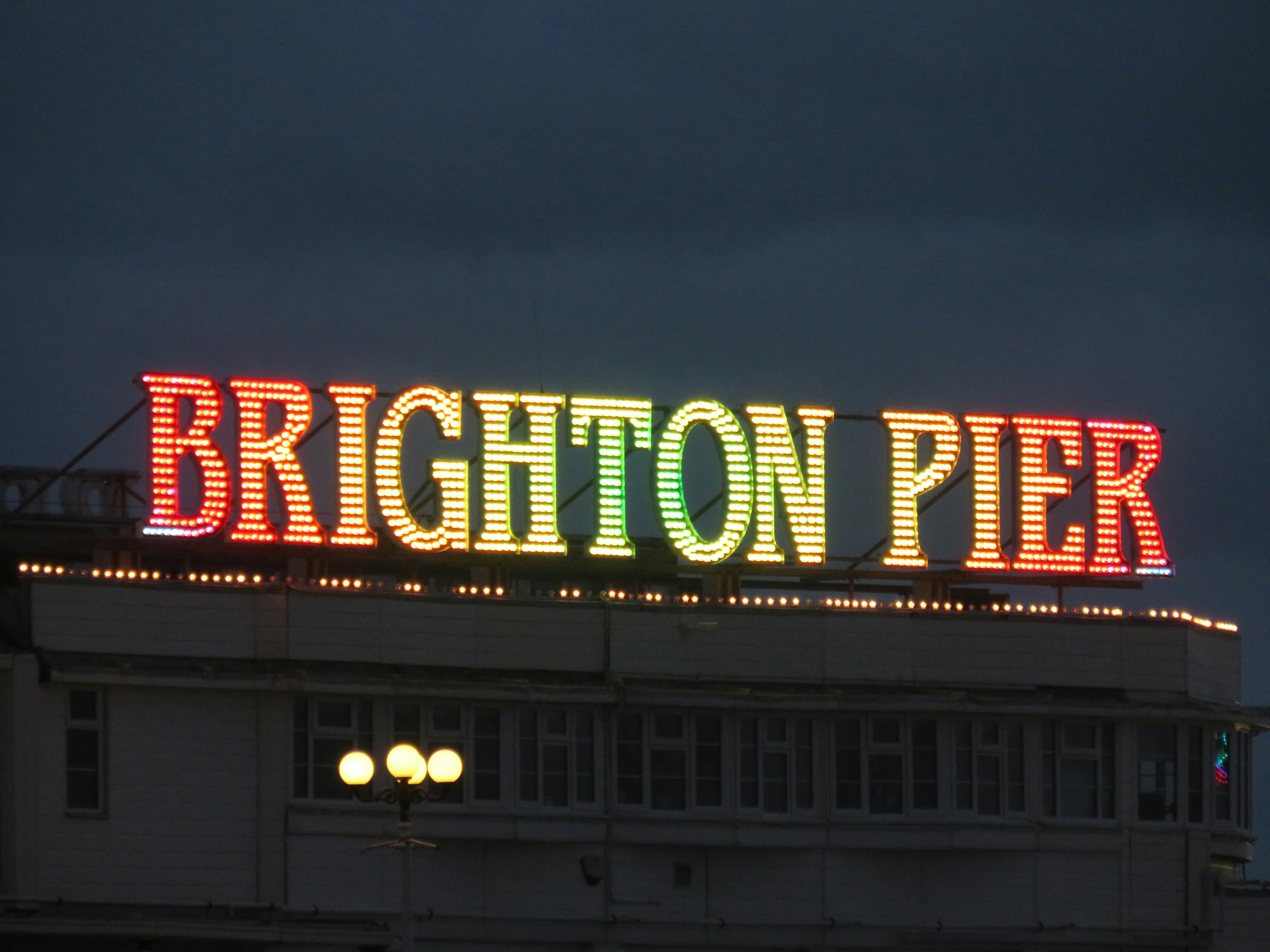 A large lighted sign on top of a building photo – Free Interior design ...