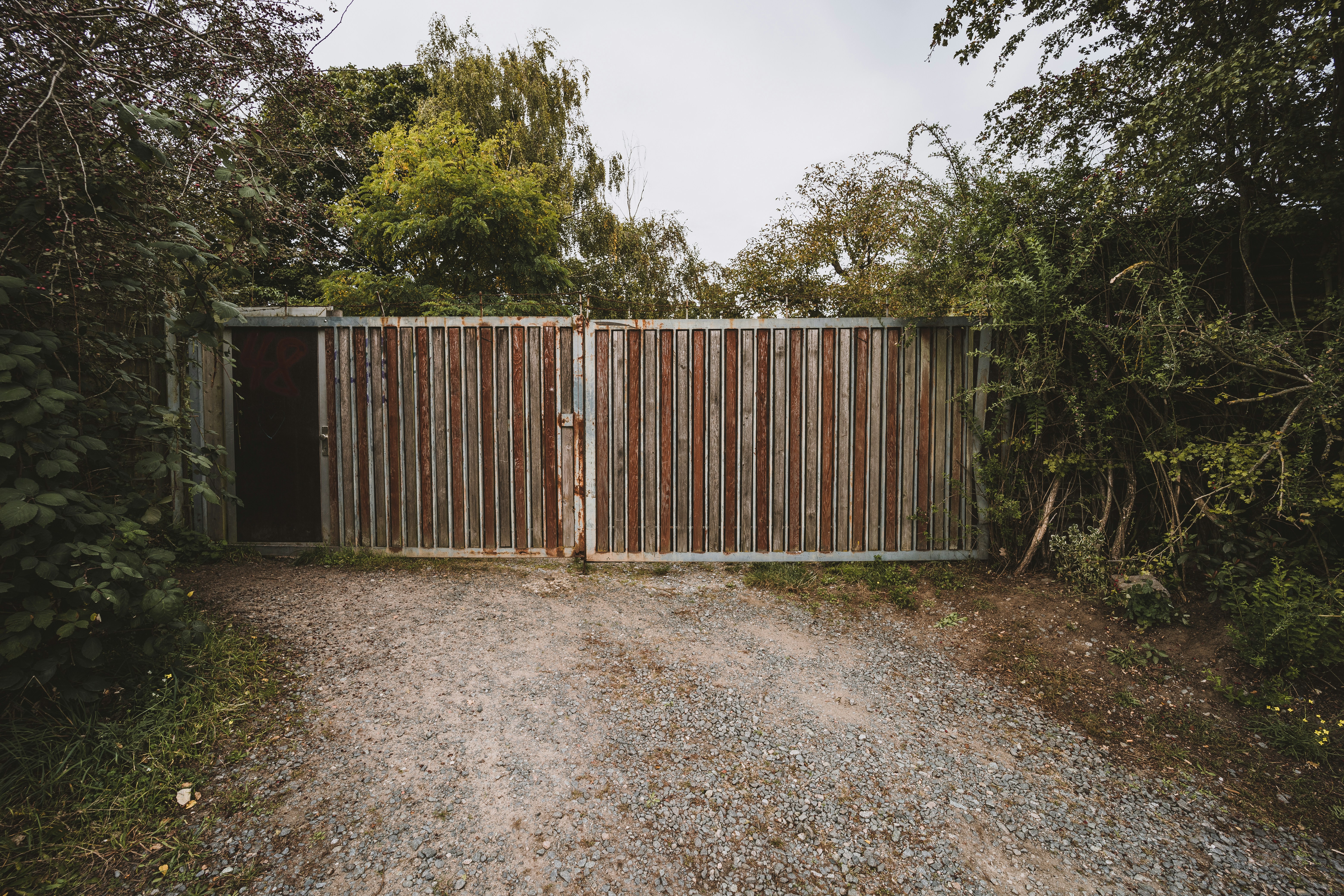 Un área cerrada con un camino de grava y árboles foto – Imagen de ...