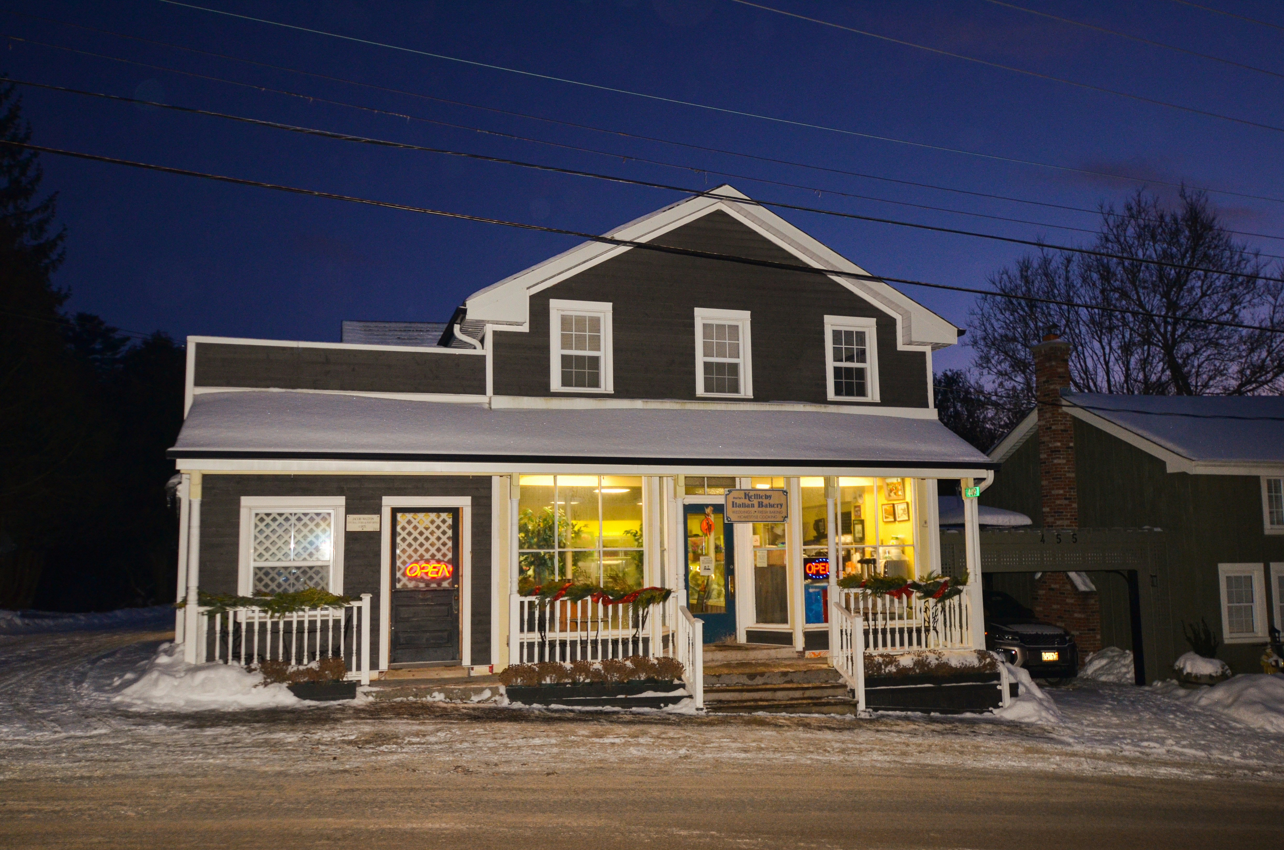 Warm Threshold on a Snowy Street: Nighttime Facade Glowing with Welcome