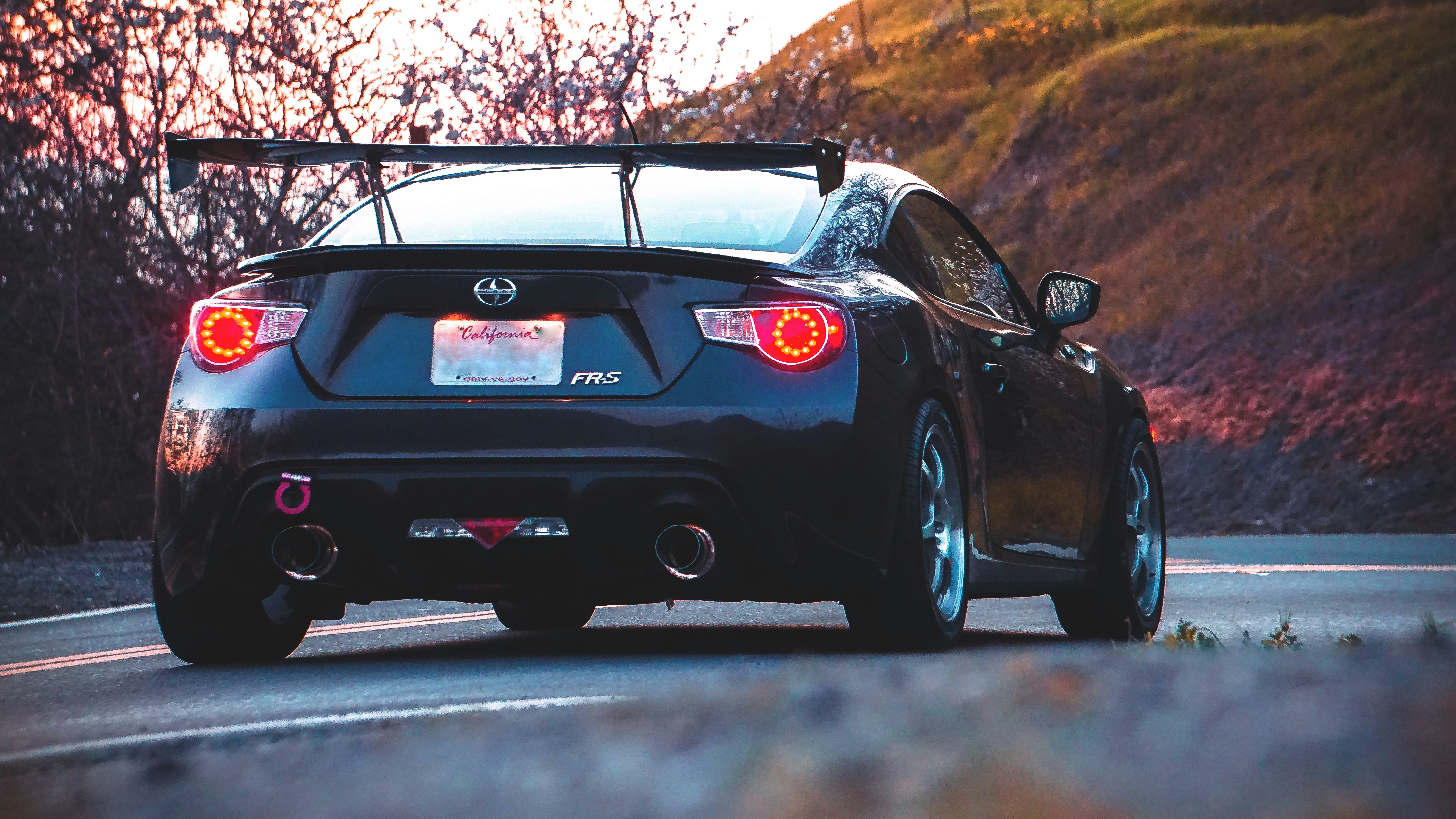 a black sports car driving down a road