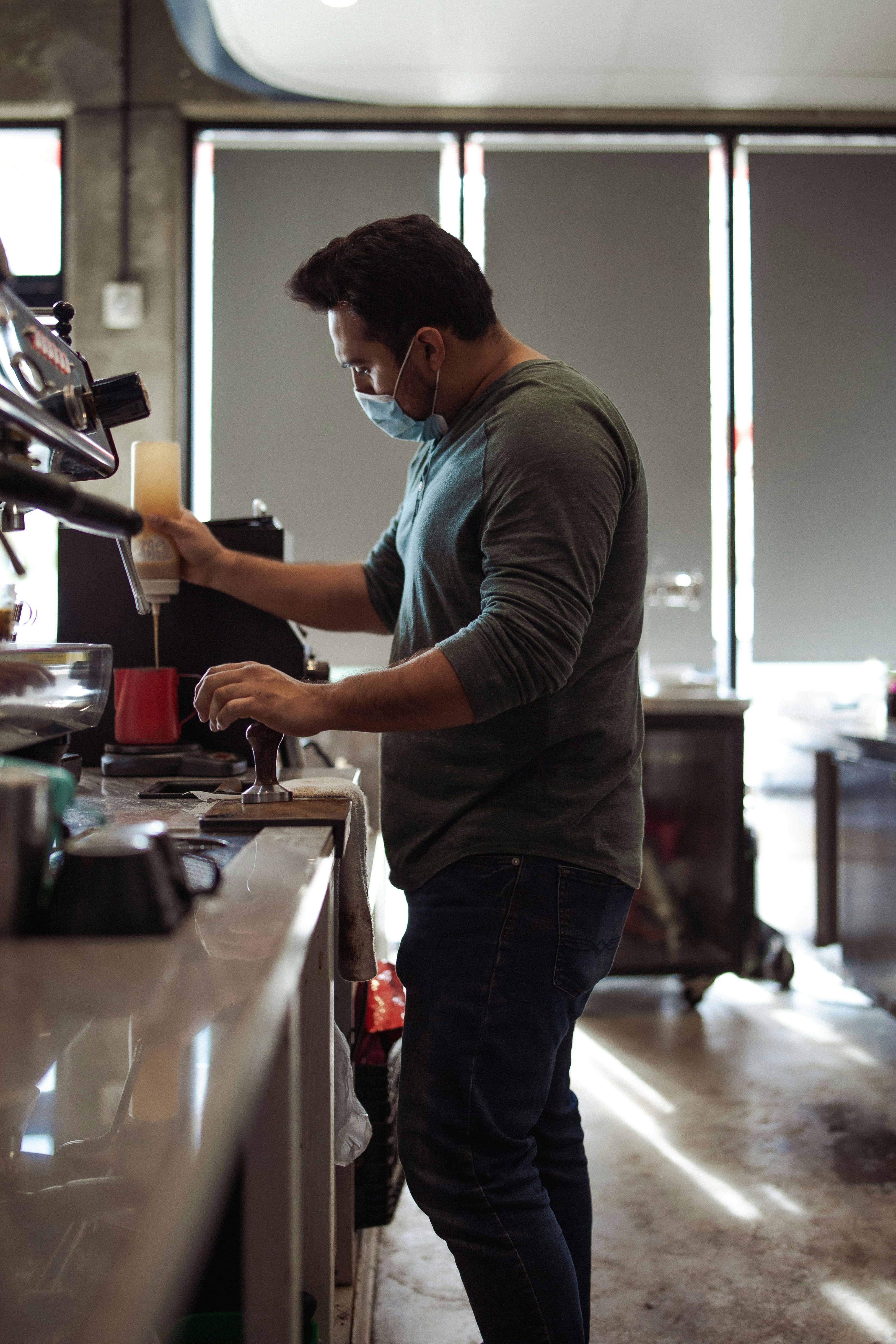 Foto Un hombre parado en un mostrador trabajando en una máquina ...
