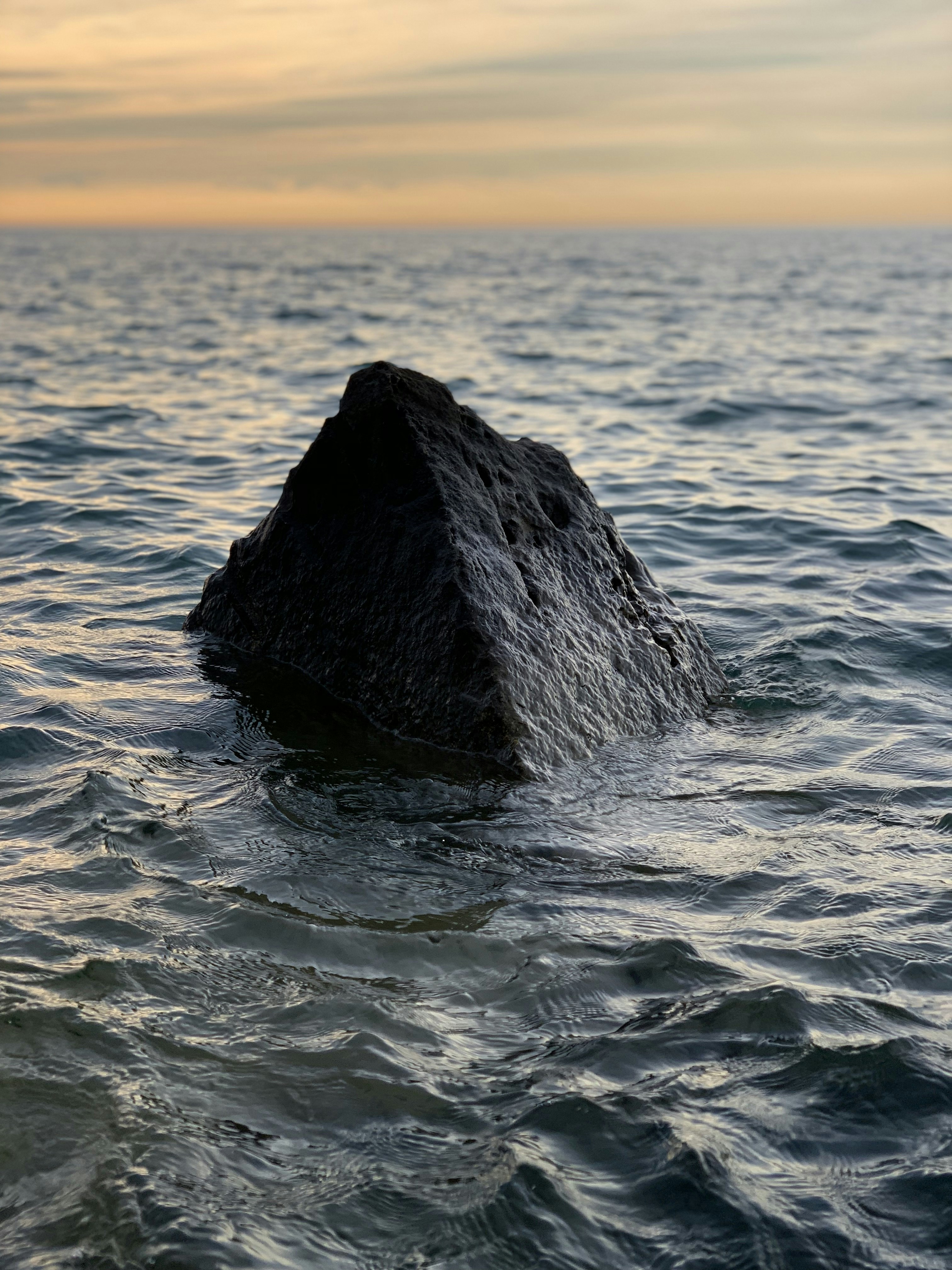 A large rock sticking out of the water photo – Free Outdoors Image on ...