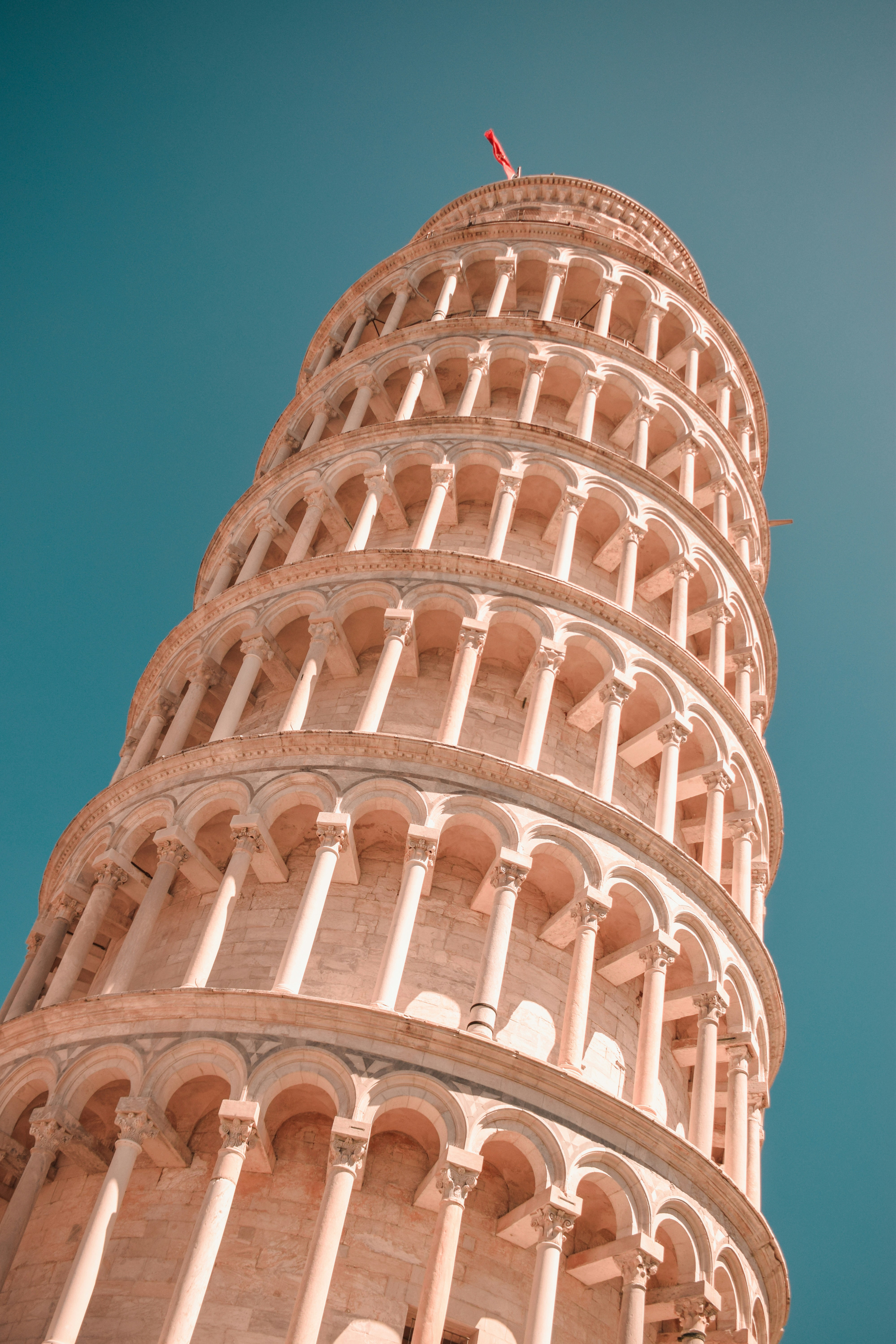 A tall tower with a flag on top of it photo – Free Pisa Image on Unsplash