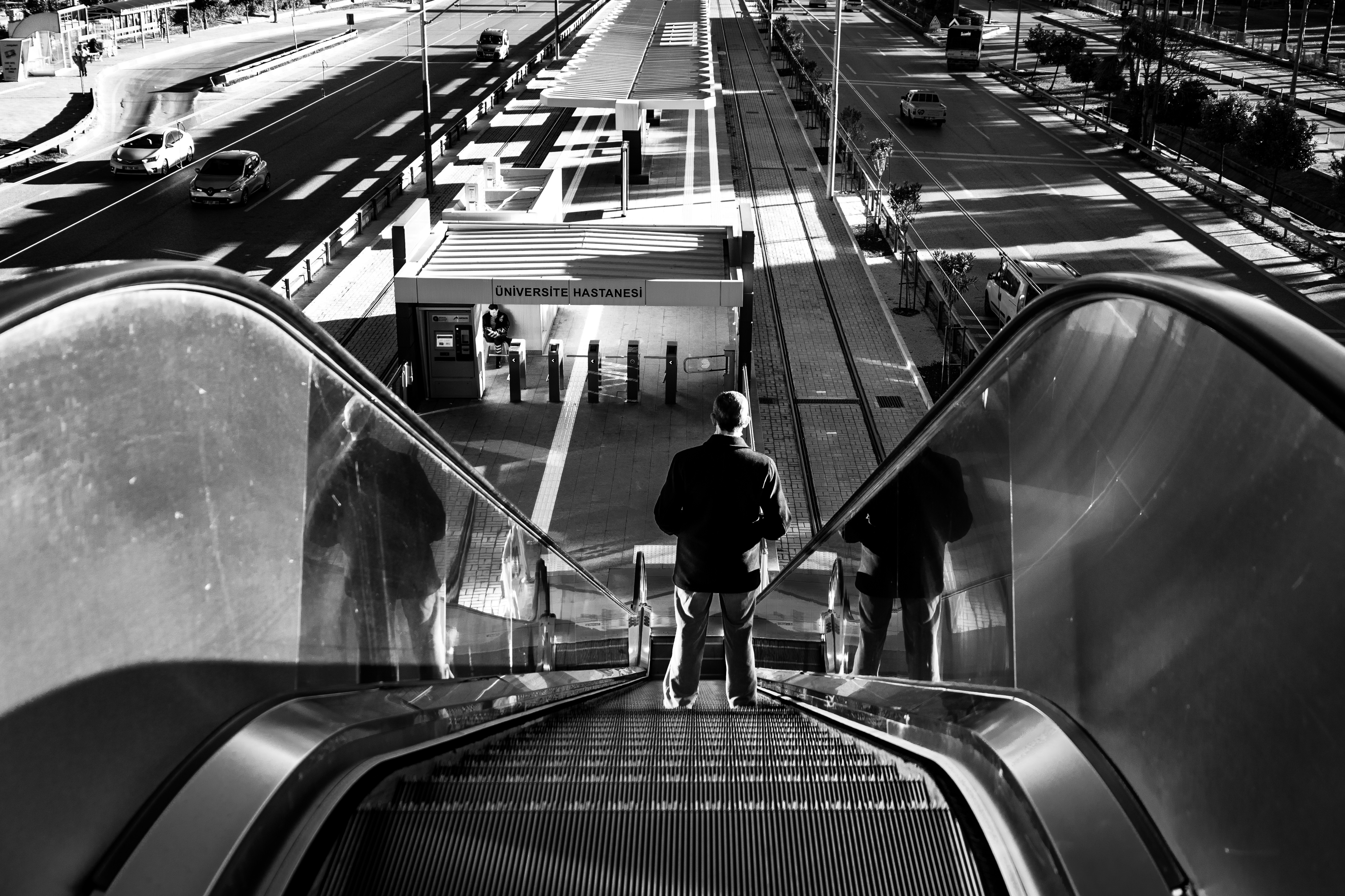 A man standing on an escalator next to an escalator photo – Free Human ...