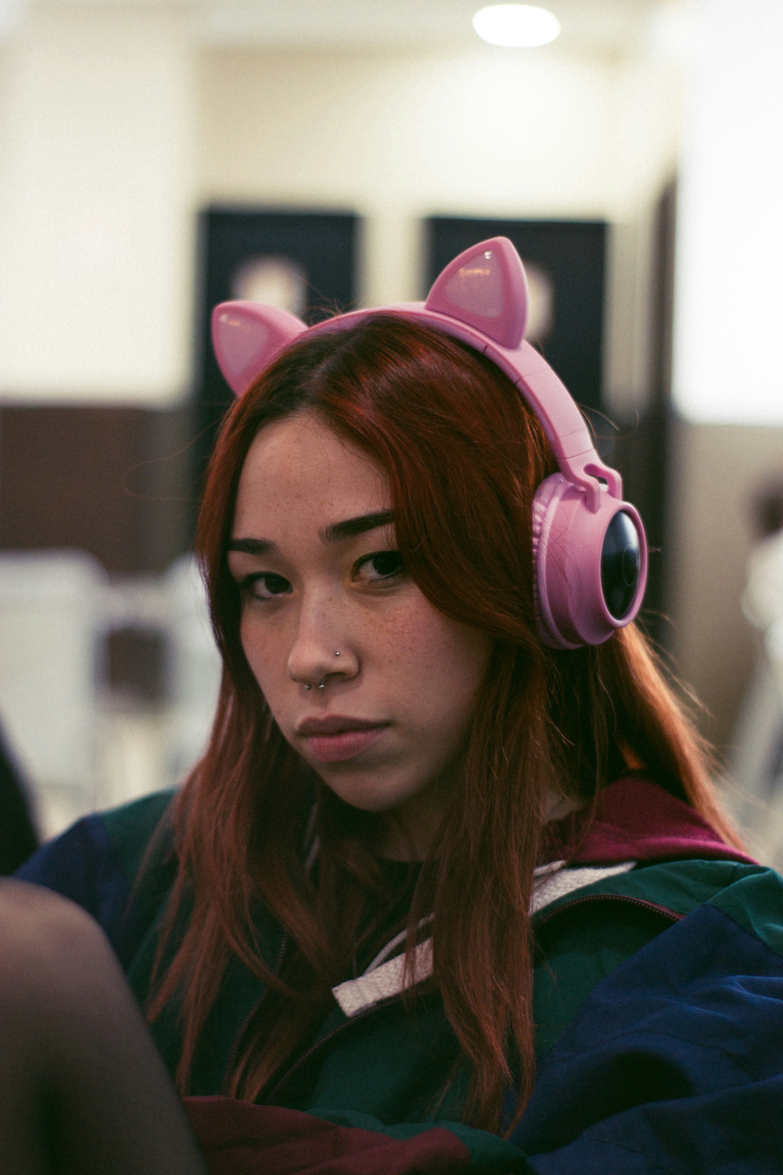 a girl with red hair wearing pink headphones