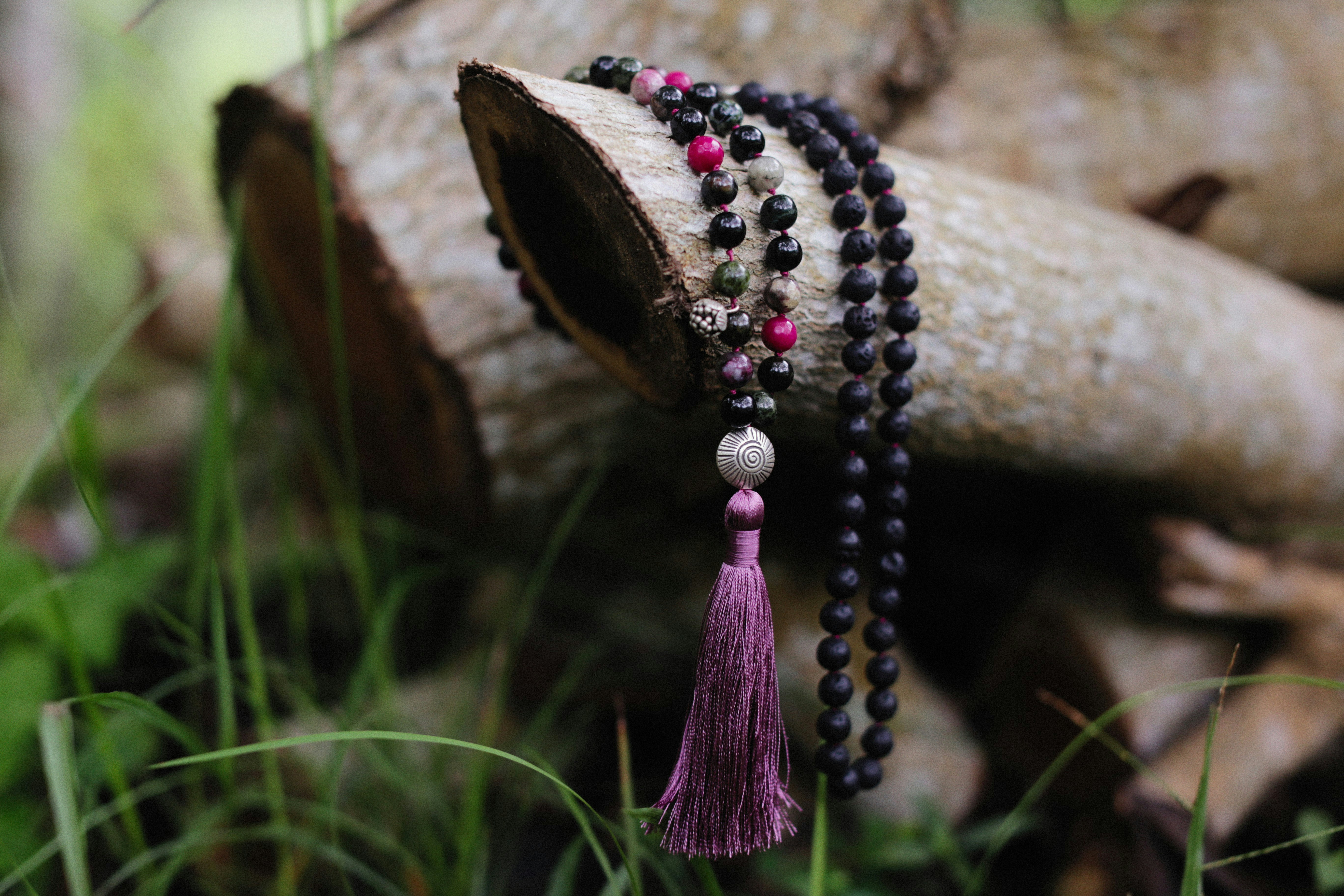 a close up of a necklace on a log
